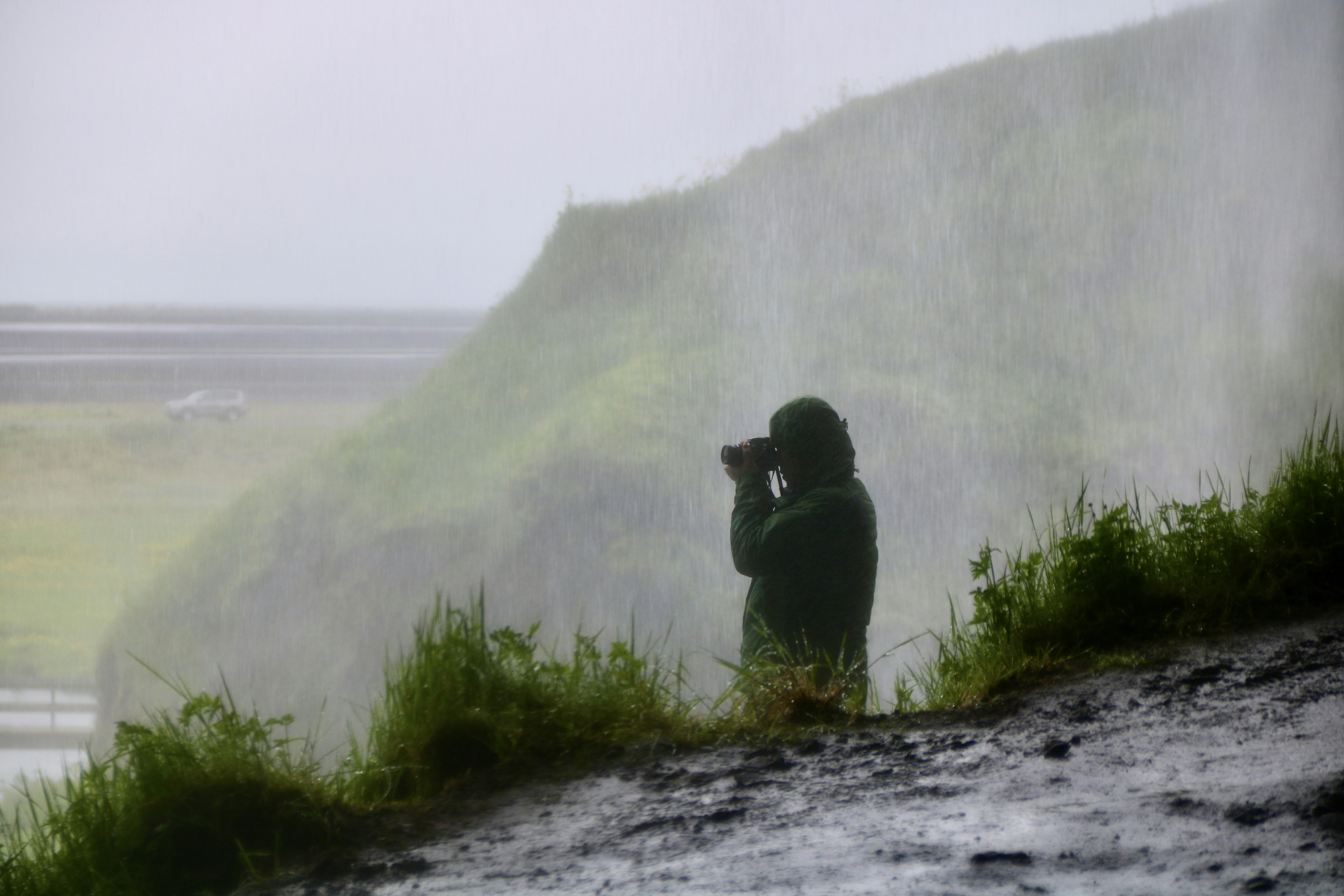 Mistbound: A Photographer Braced by Green Cliffs and Salt Spray