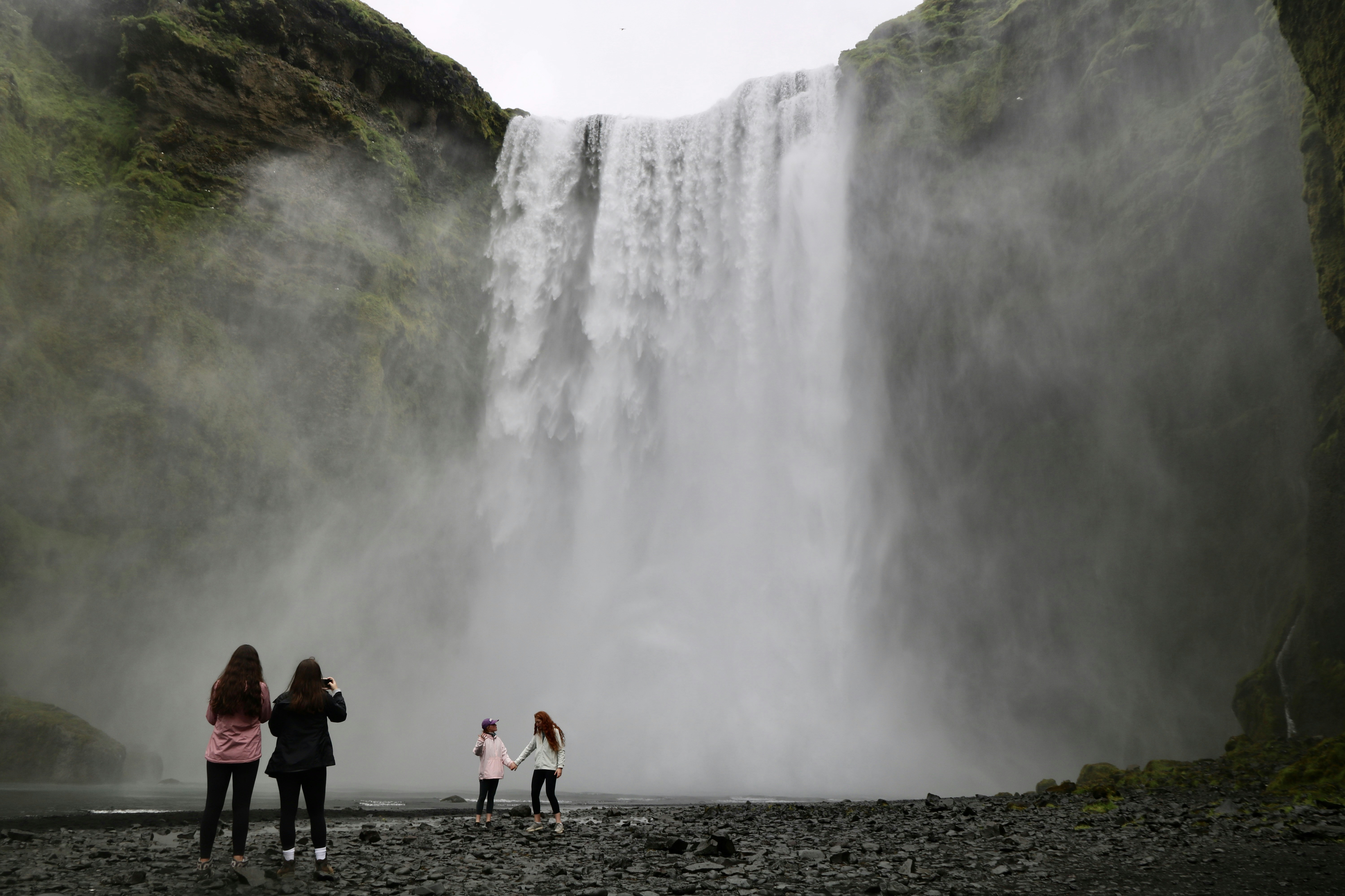 Un groupe de personnes debout devant une cascade photo – Photo ...