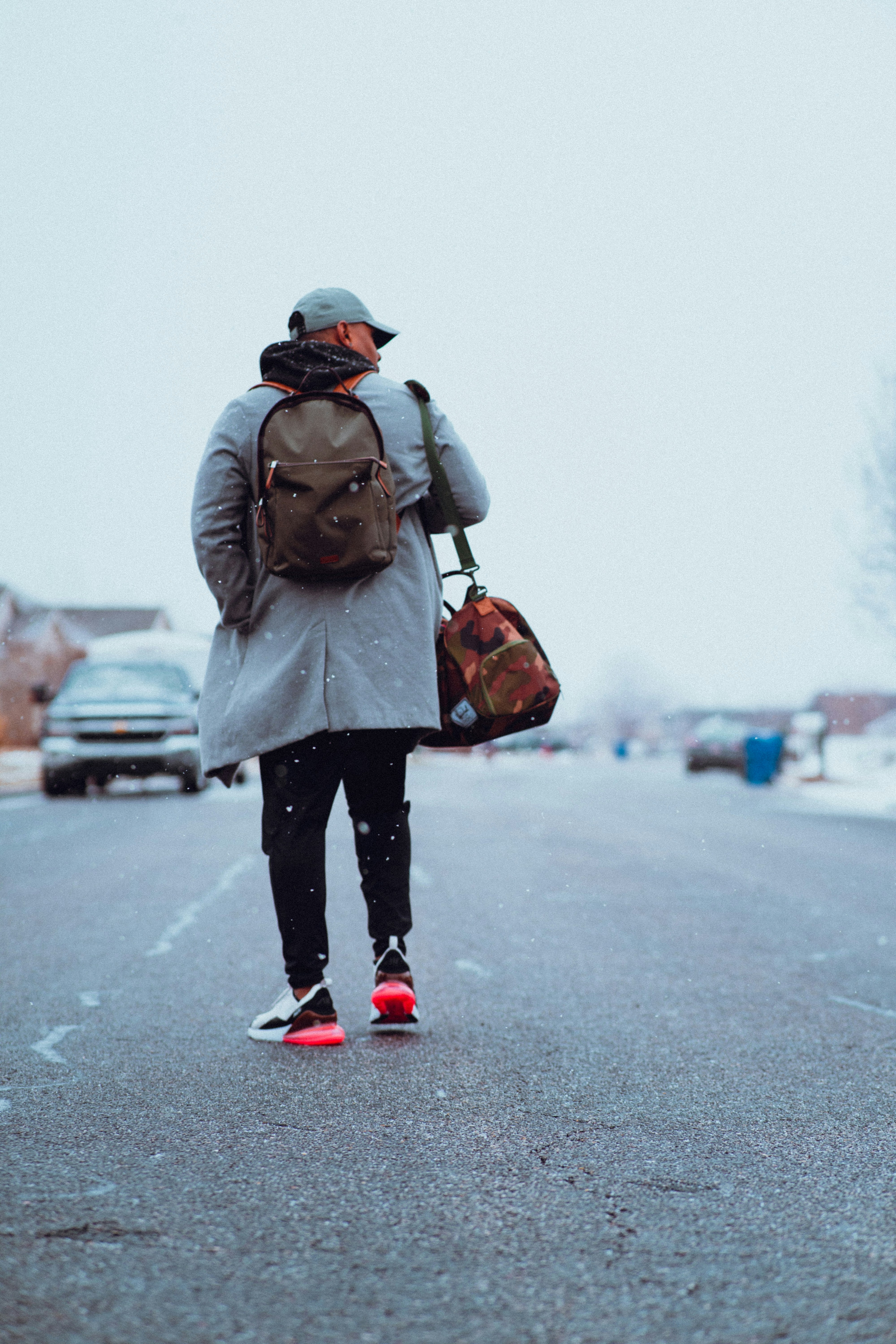 Midwinter Journey: A Lone Backpacker on a Snow-Dusted Street