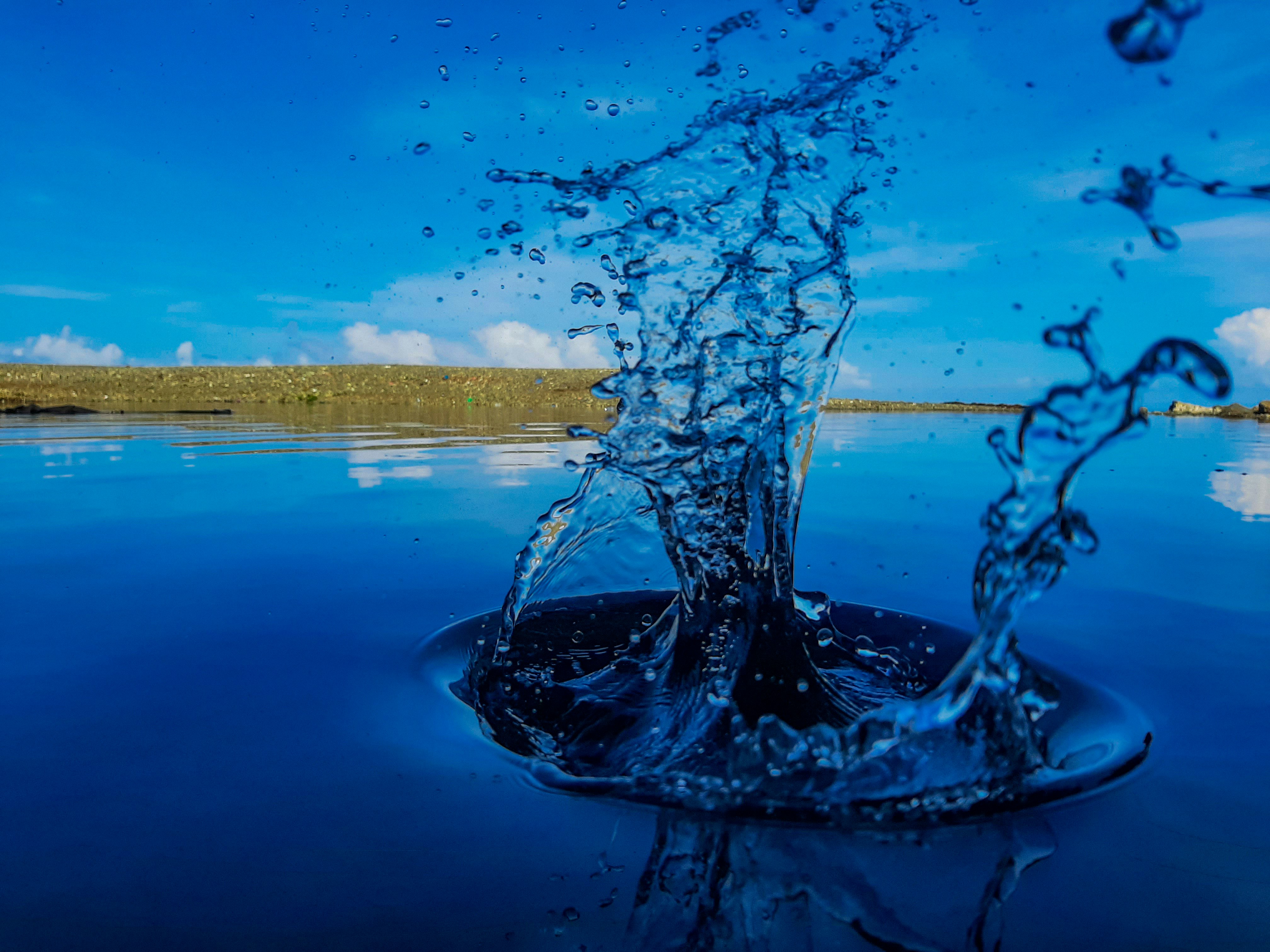 Cobalt Crest: A Freeze-Frame Eruption on a Calm Blue Mirror
