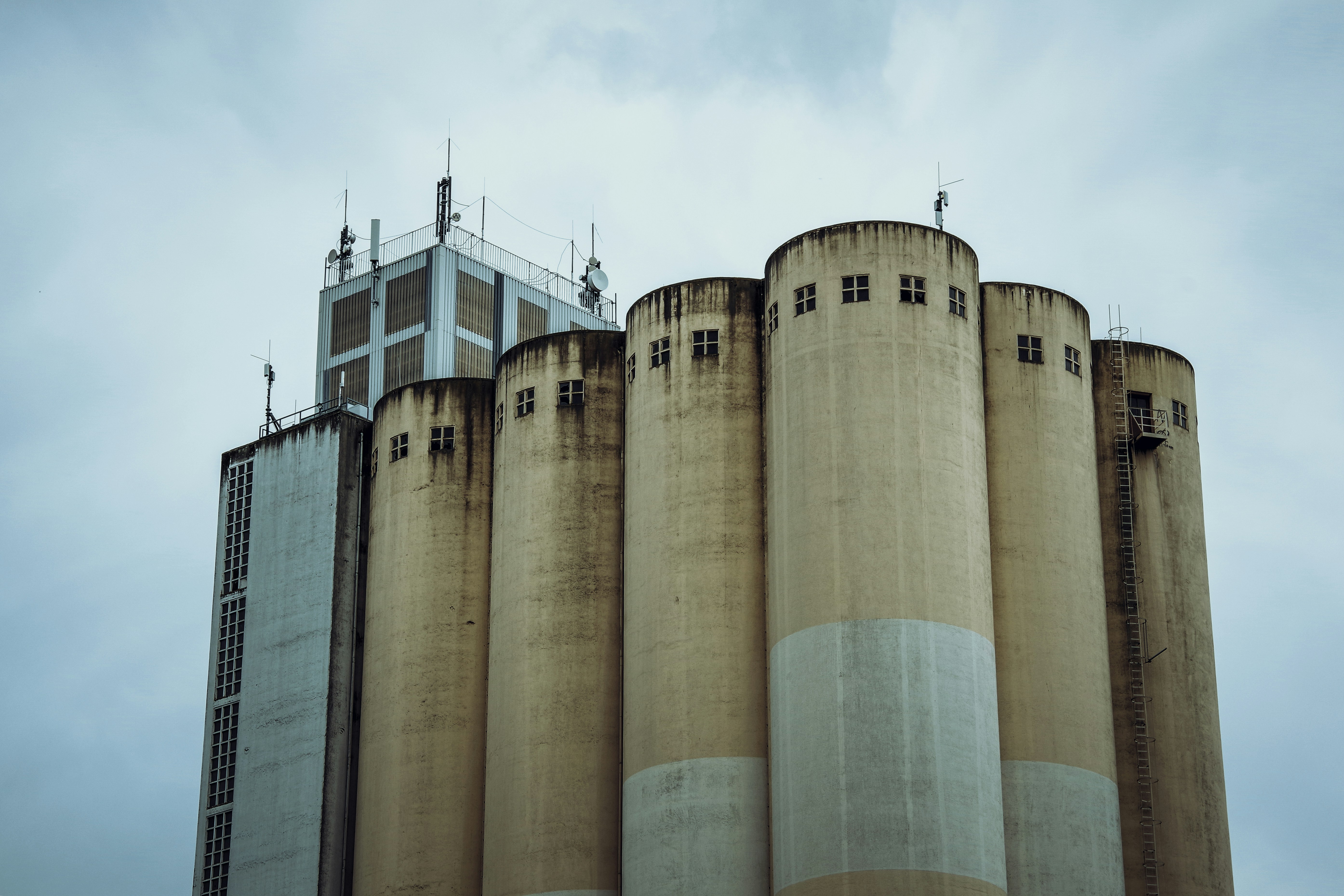 Grain silos of former "Wesermühlen Hameln". Decommissioned in 2013. | a very tall building with a clock on it's side