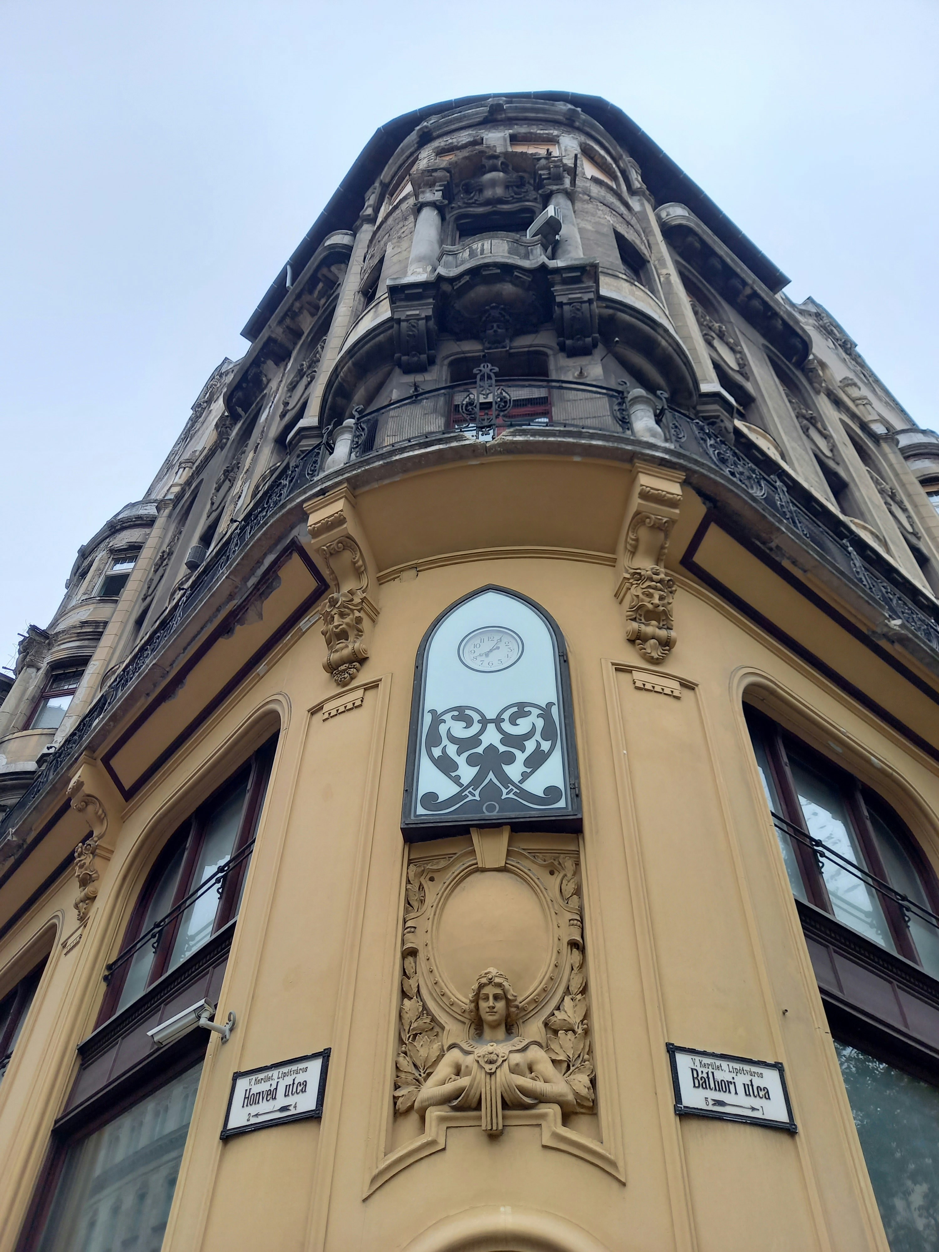 Intricate architectural details of a historic building captured from a low angle, showcasing its ornate design and signage.