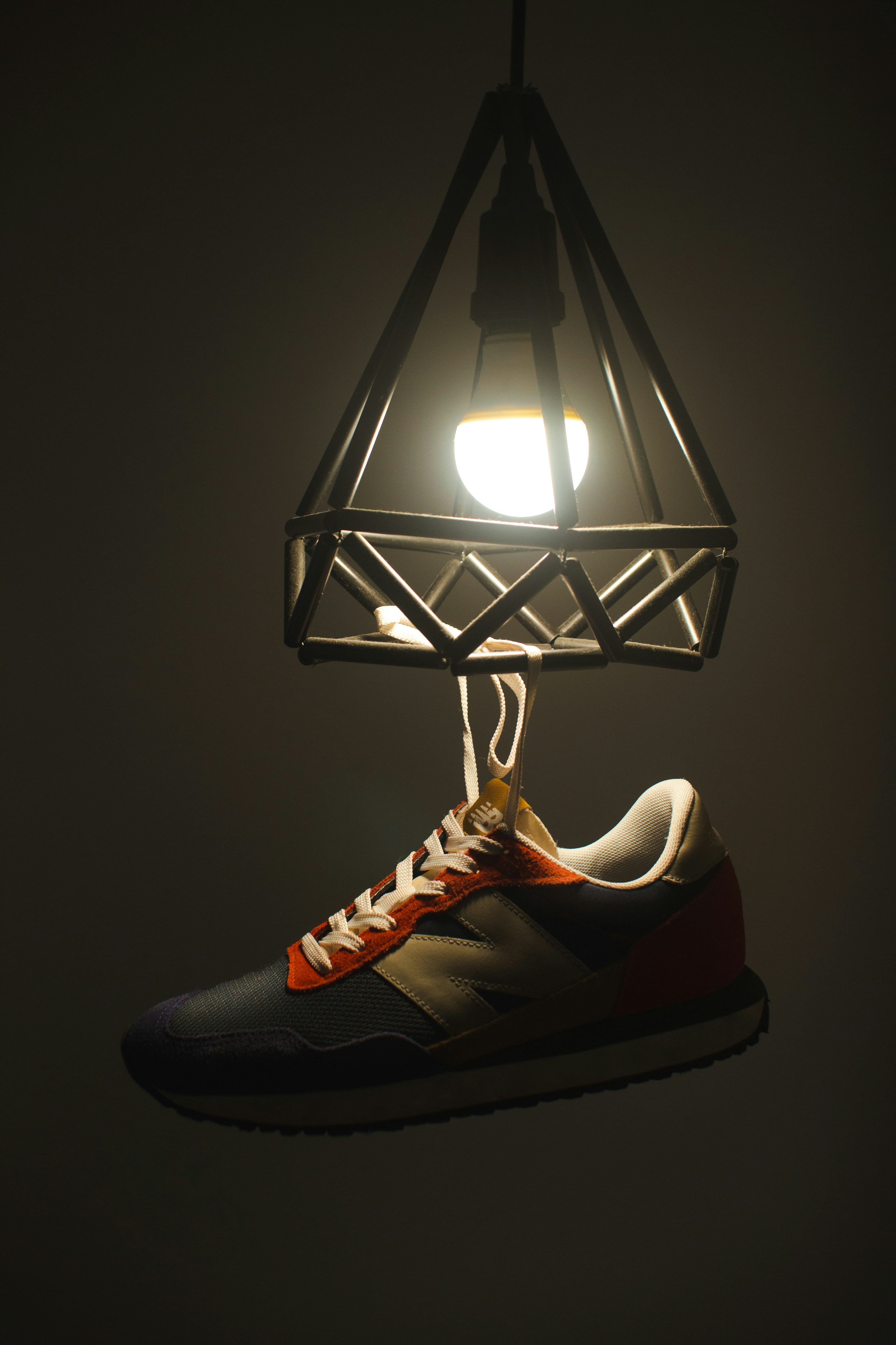 A pair of sneakers hanging from a light fixture photo – Free Mood Image ...