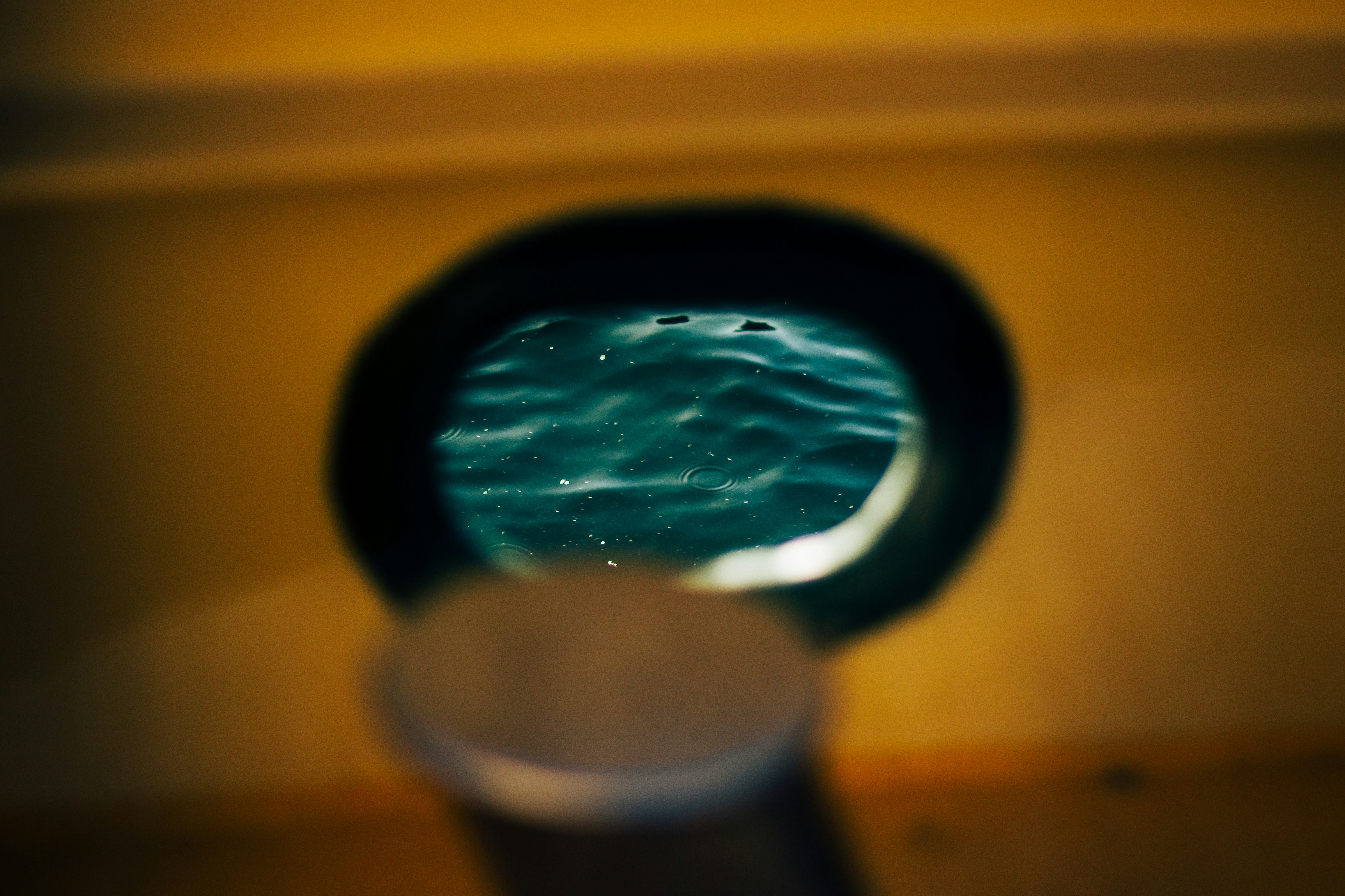 Teal Ripples Framed by a Warm Porthole