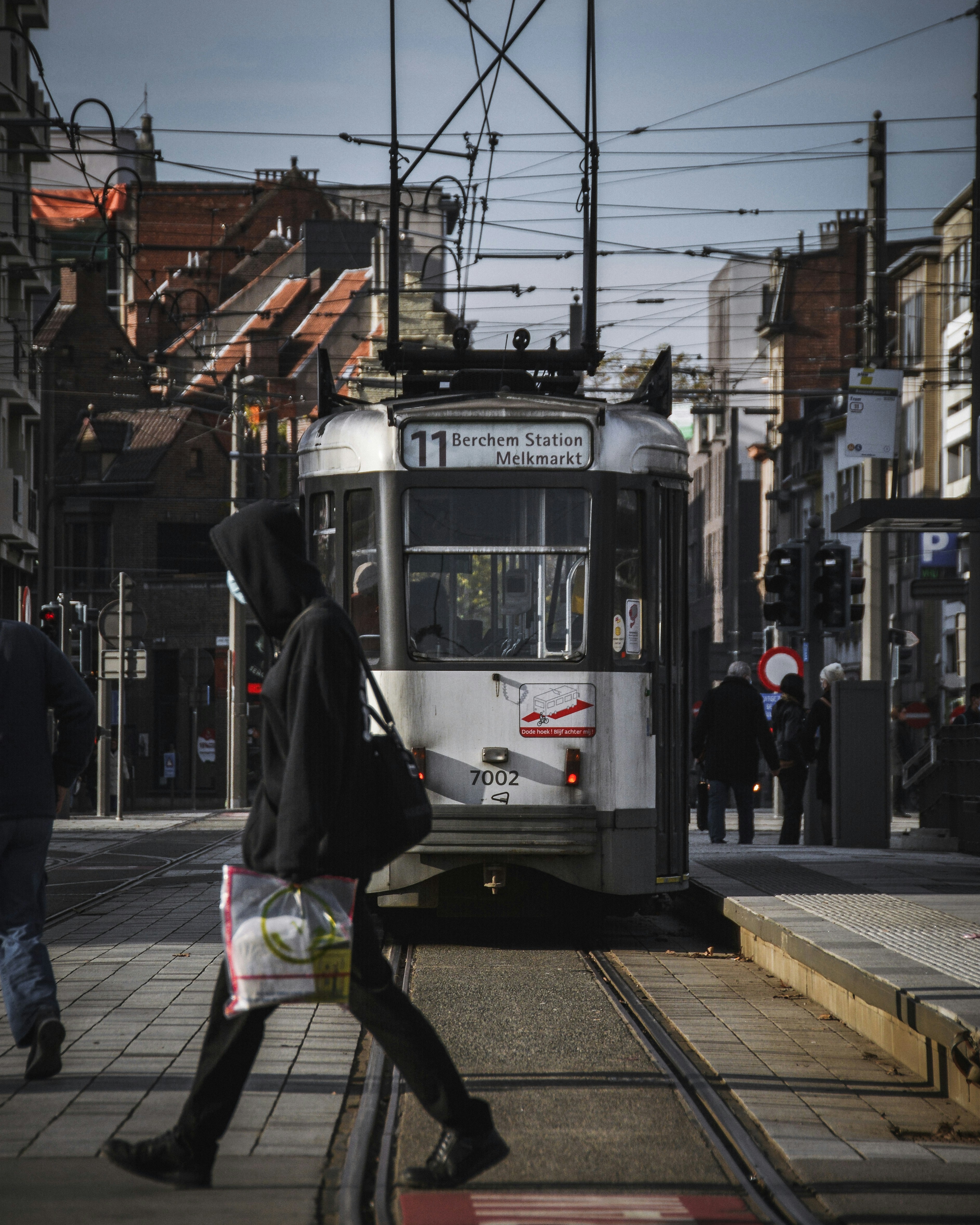 Morning Tram at Berchem: Pedestrian Crossing the Tracks