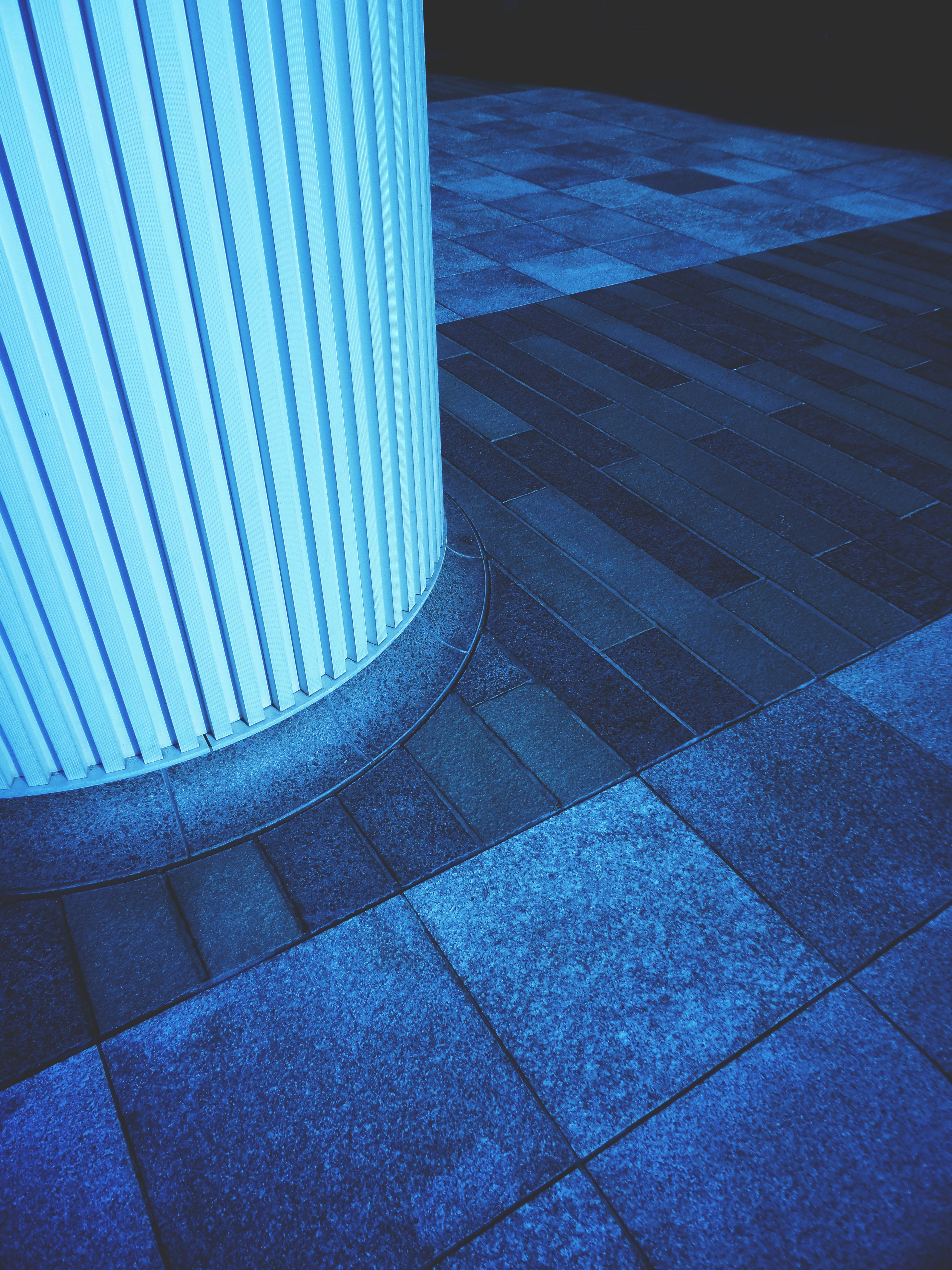 Blue Hour Curvature: Ribbed Column Anchoring a Geometric Plaza