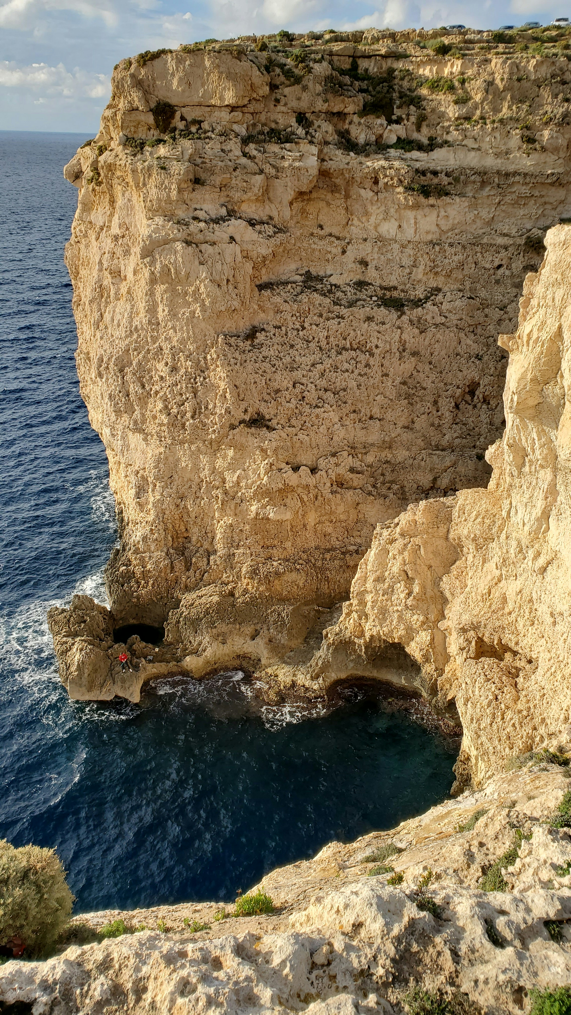 A rocky cliff overlooks a body of water photo – Free Malta Image on ...