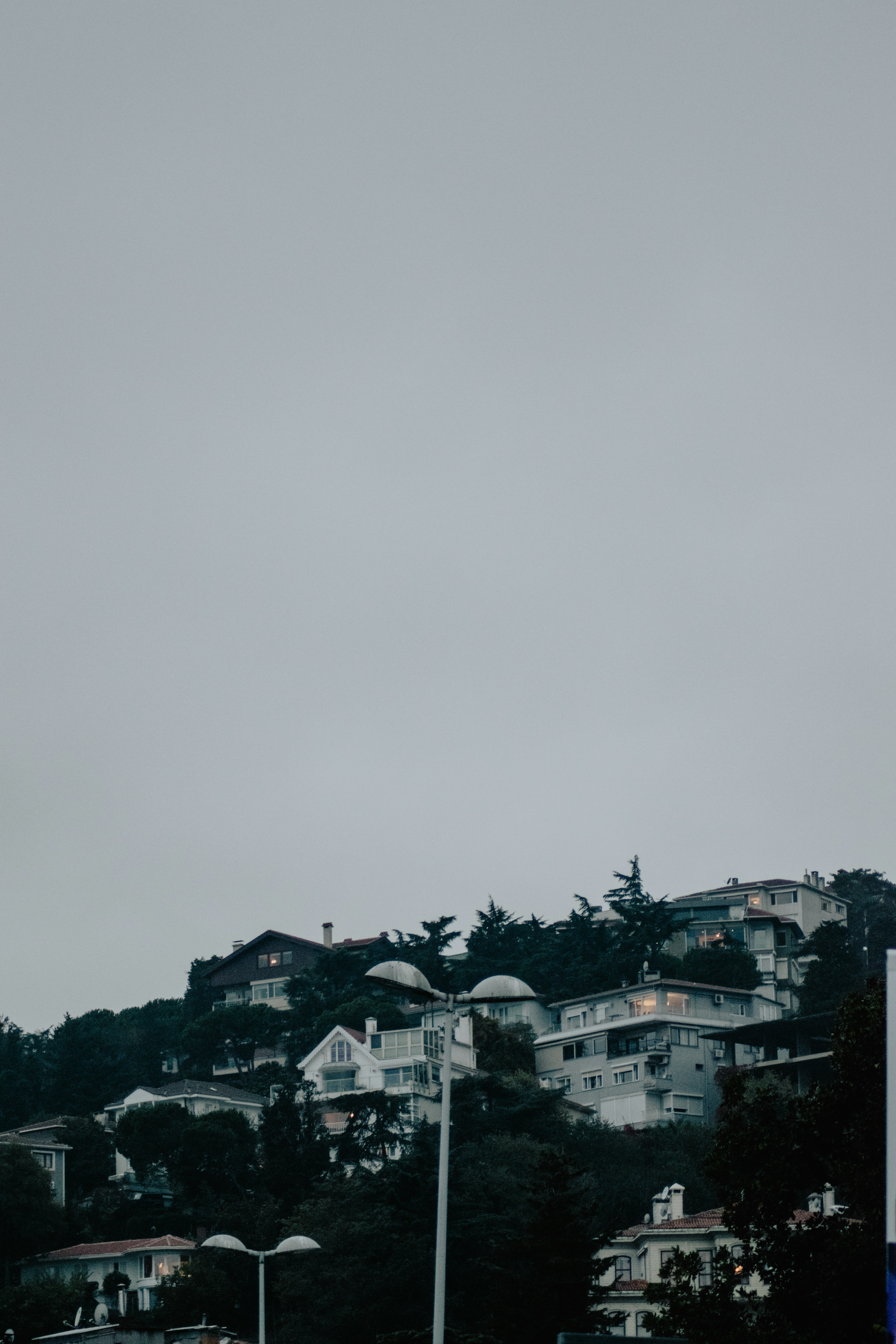 Lamplight on the Hillside: Quiet Crest Beneath a Dim Sky