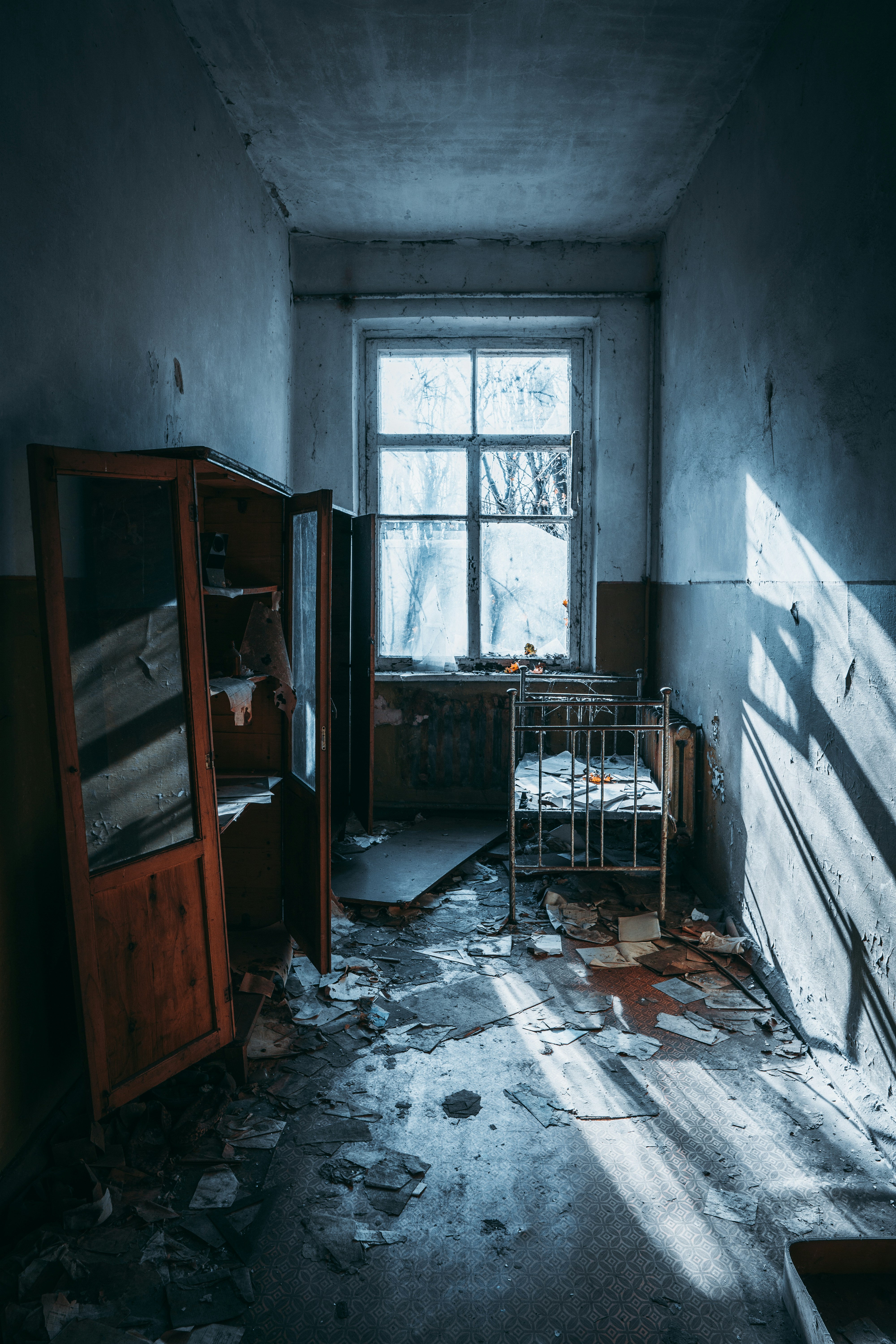 A run down room with a bed and a window photo – Free Building Image on ...