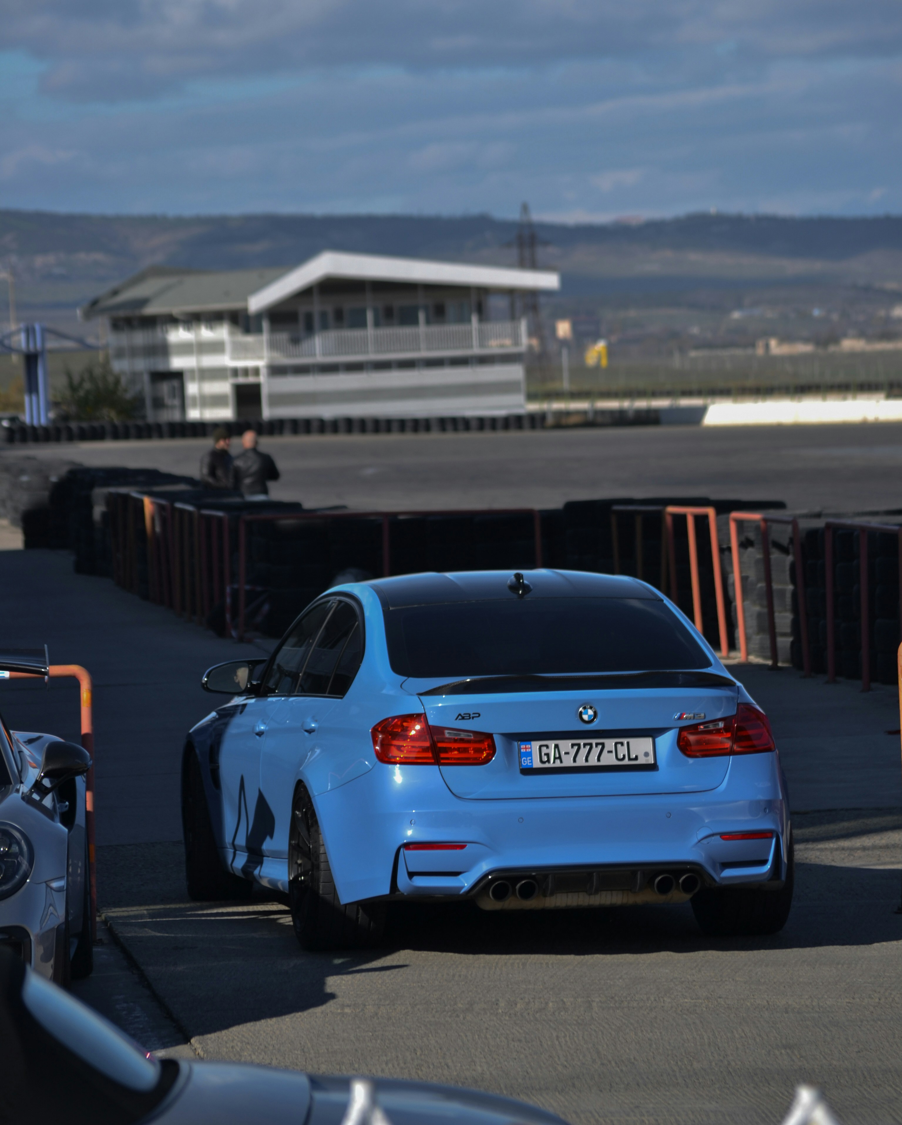 A blue car driving down a race track photo – Free Rustavi international ...