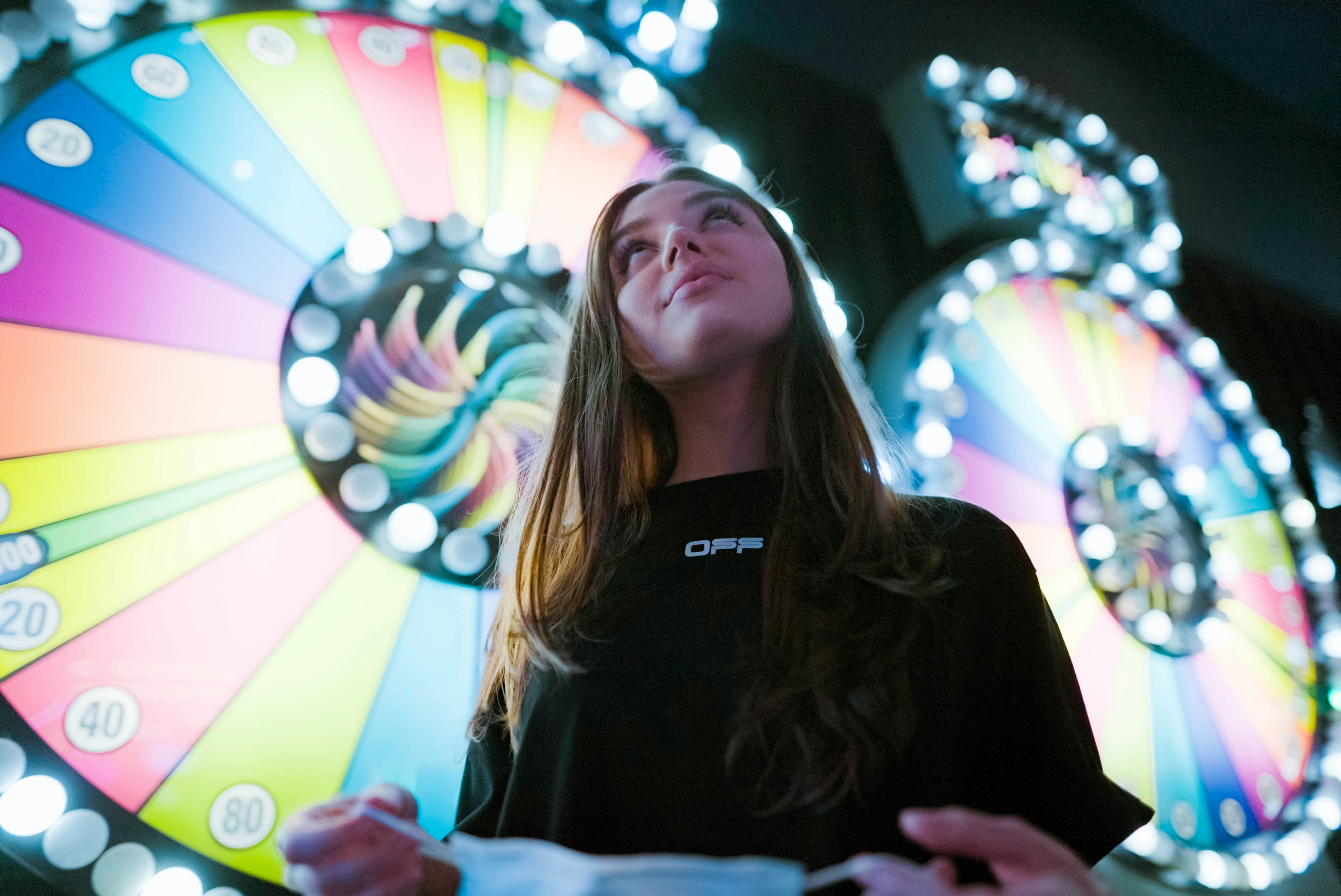 Une femme debout devant une roue de la fortune photo – Photo La ...