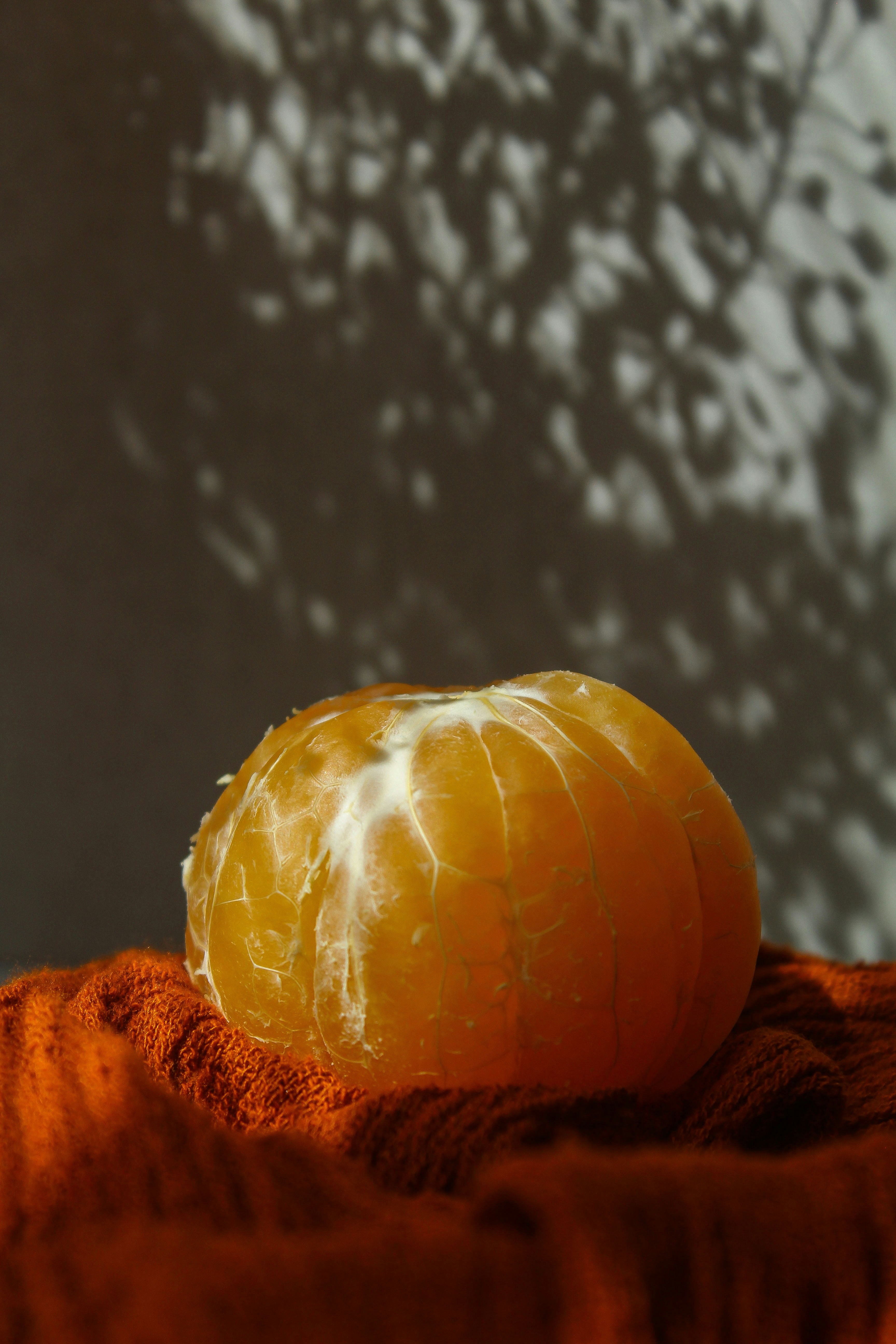 an orange sitting on top of an orange towel