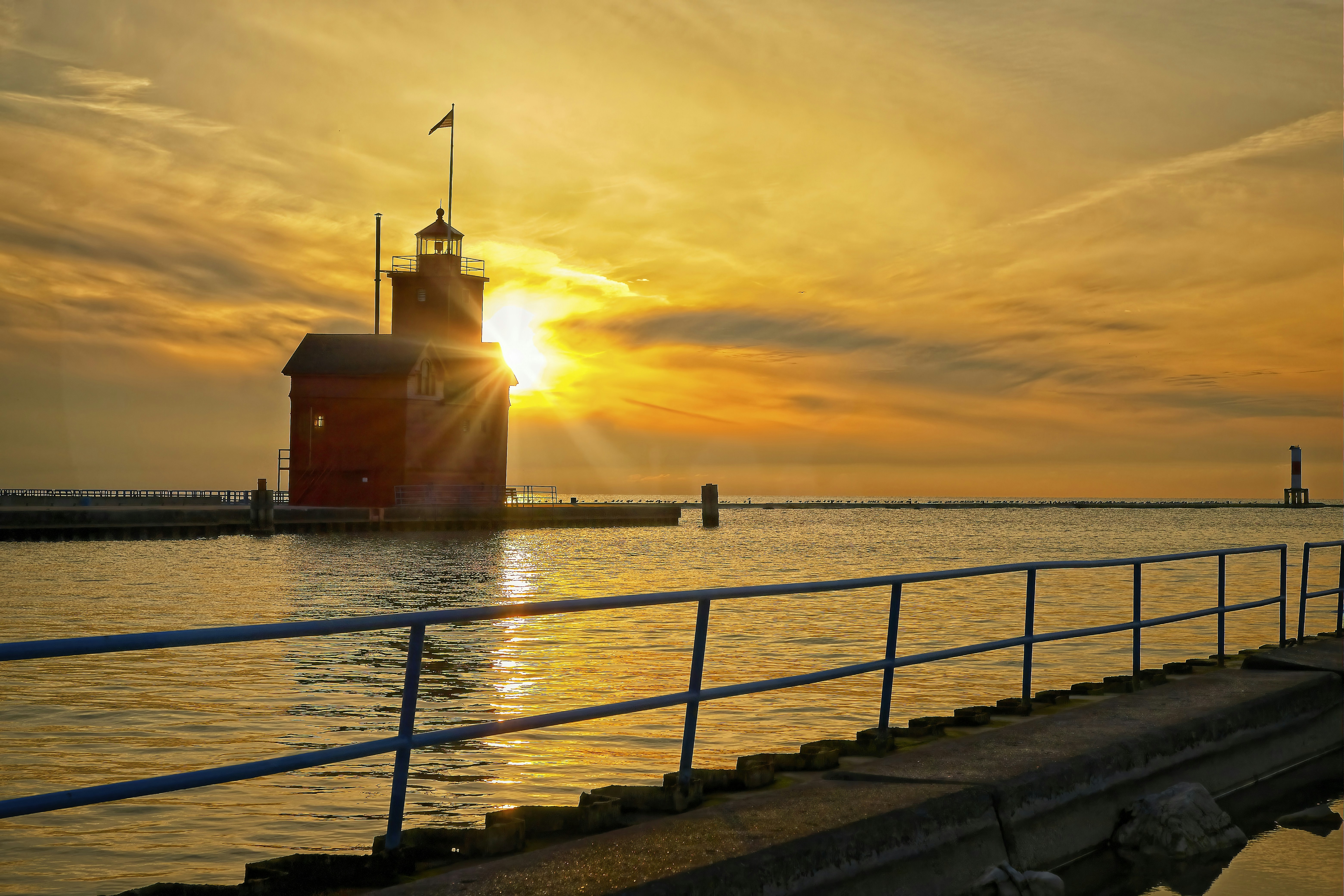 A light house sitting on top of a pier next to the ocean photo – Free ...