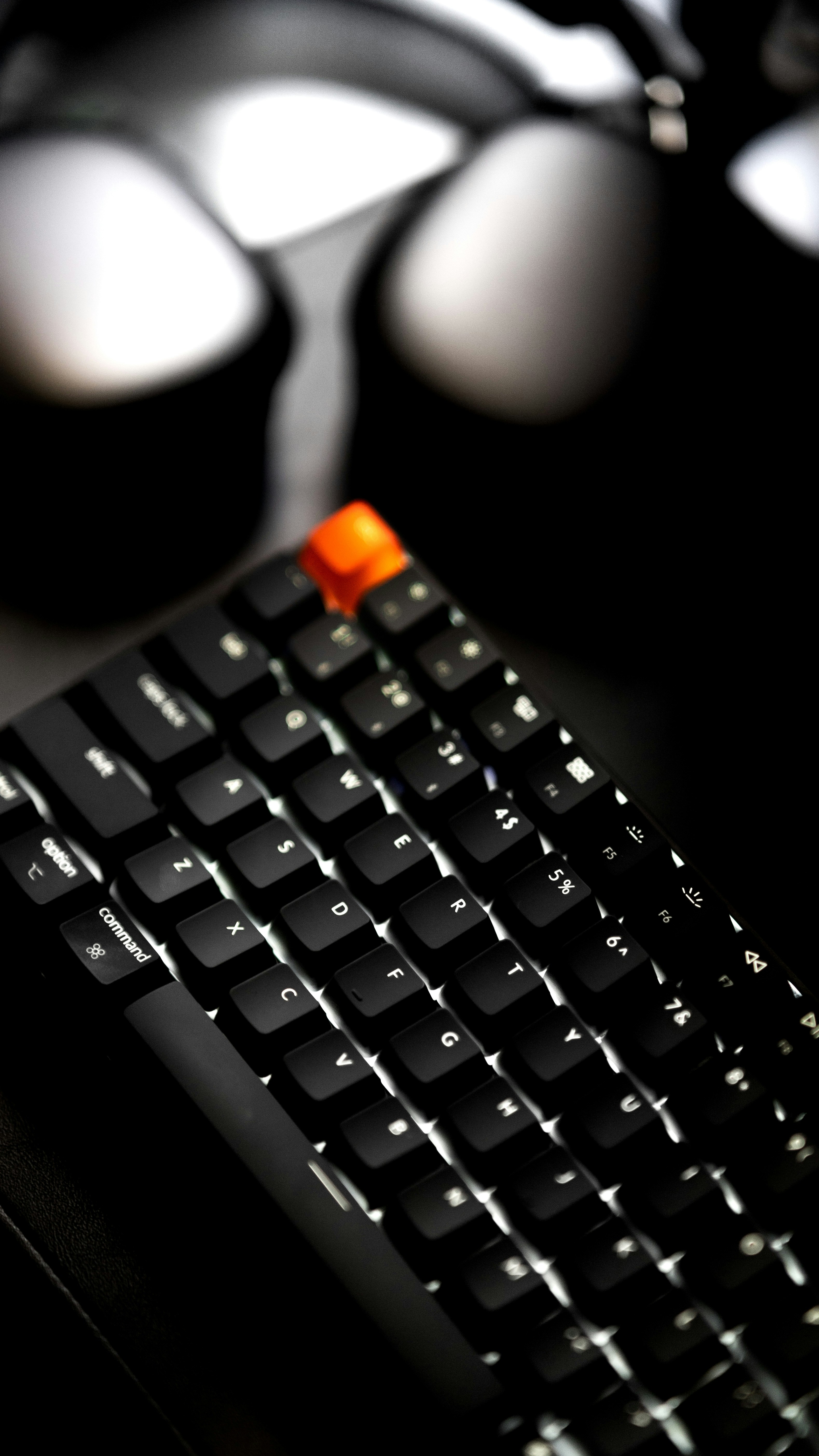 Backlit Glow on a Neon Orange Keycap Above the Keyboard