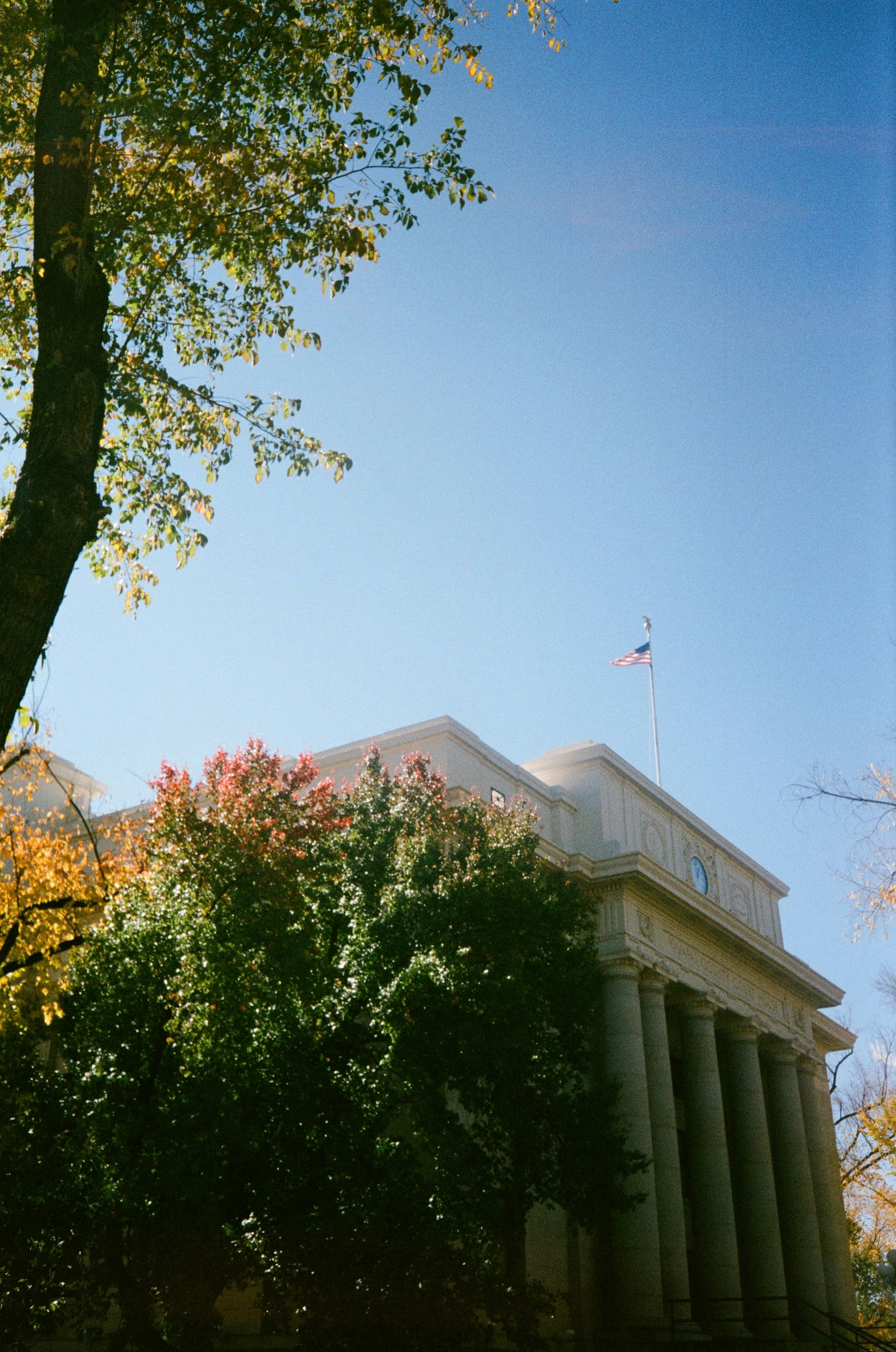 Flag atop Neoclassical Facade Under a Clear Autumn Sky