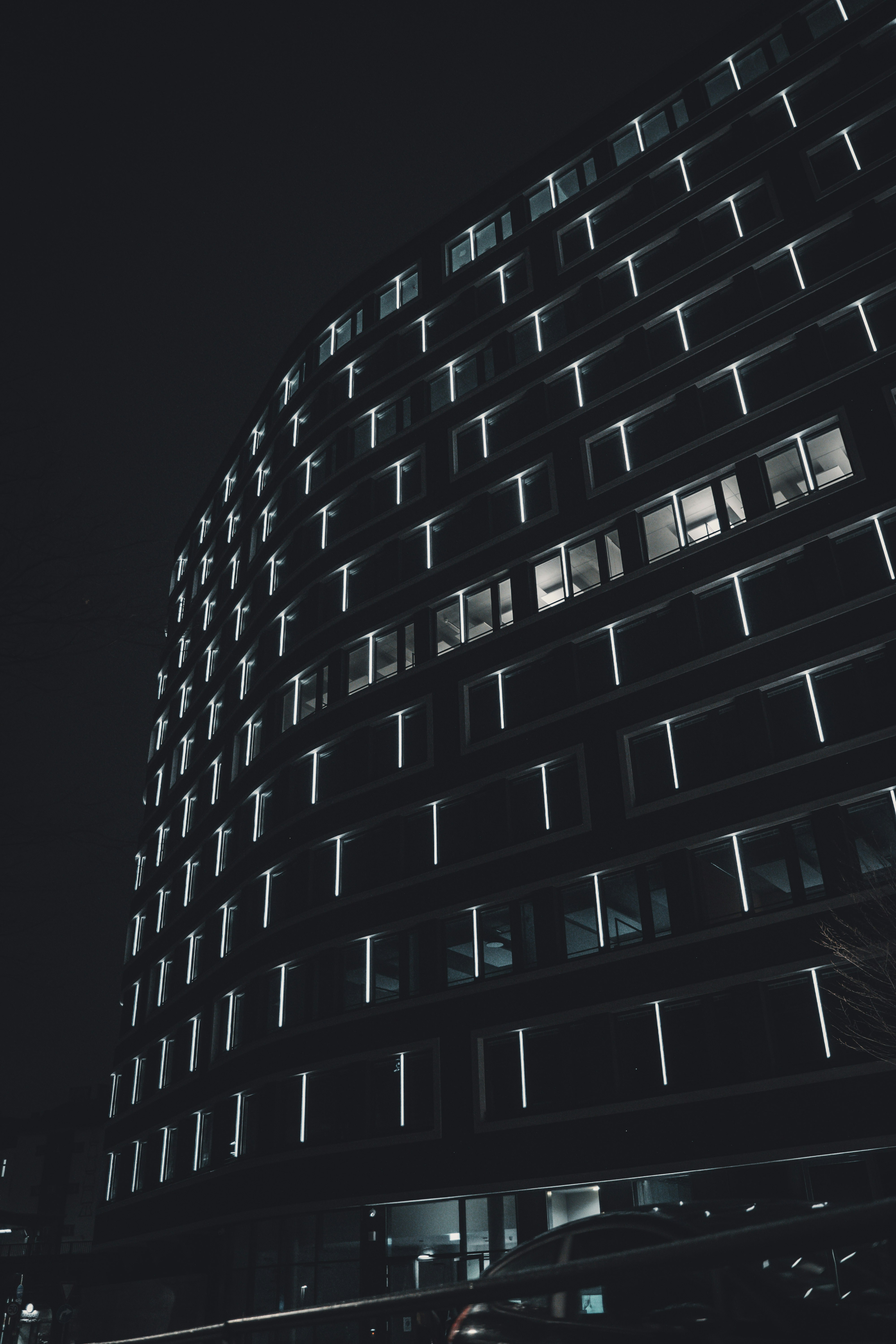 Modern building façade illuminated by sleek vertical lights, showcasing a blend of architecture and urban ambiance.
