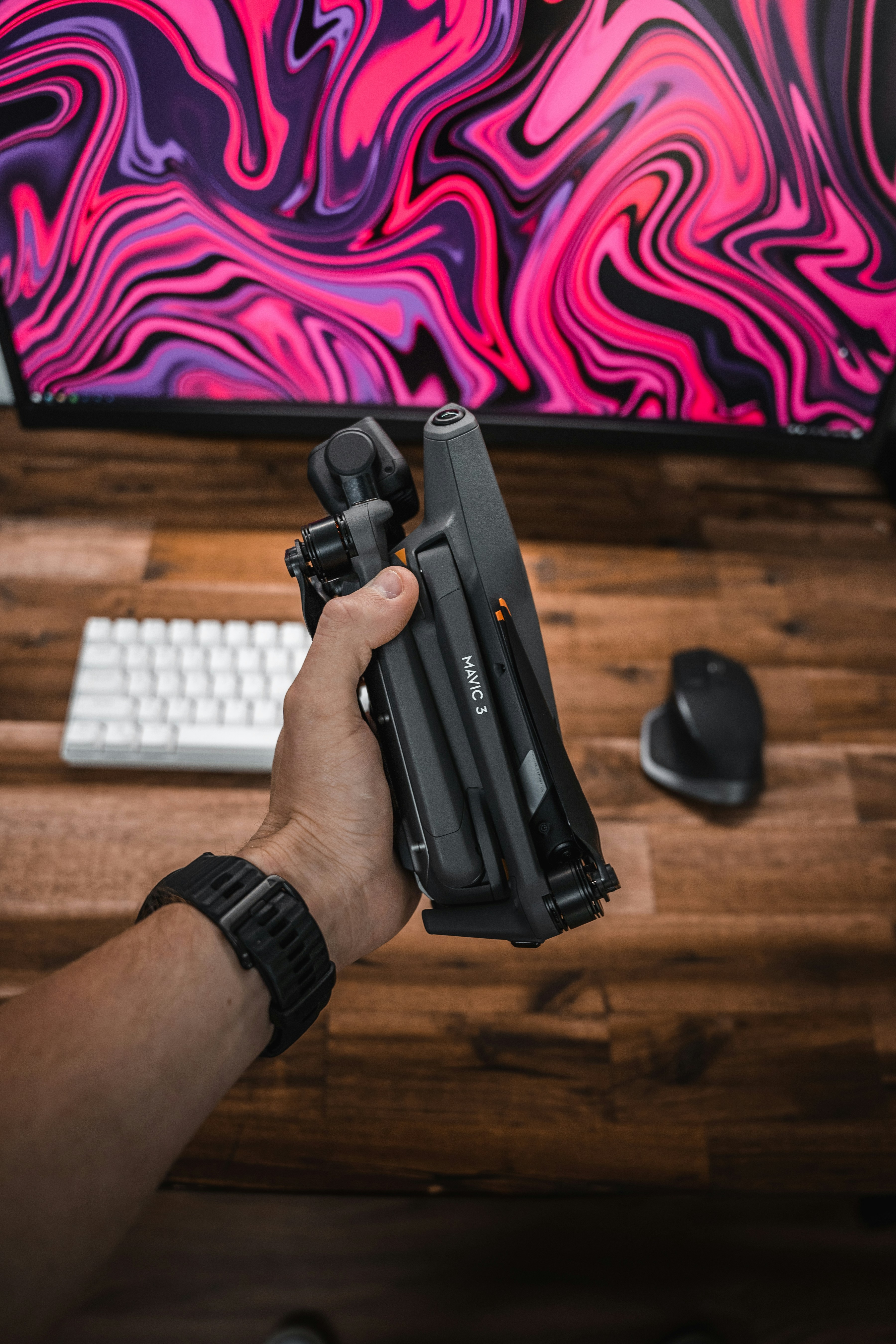 a person holding a camera in front of a computer