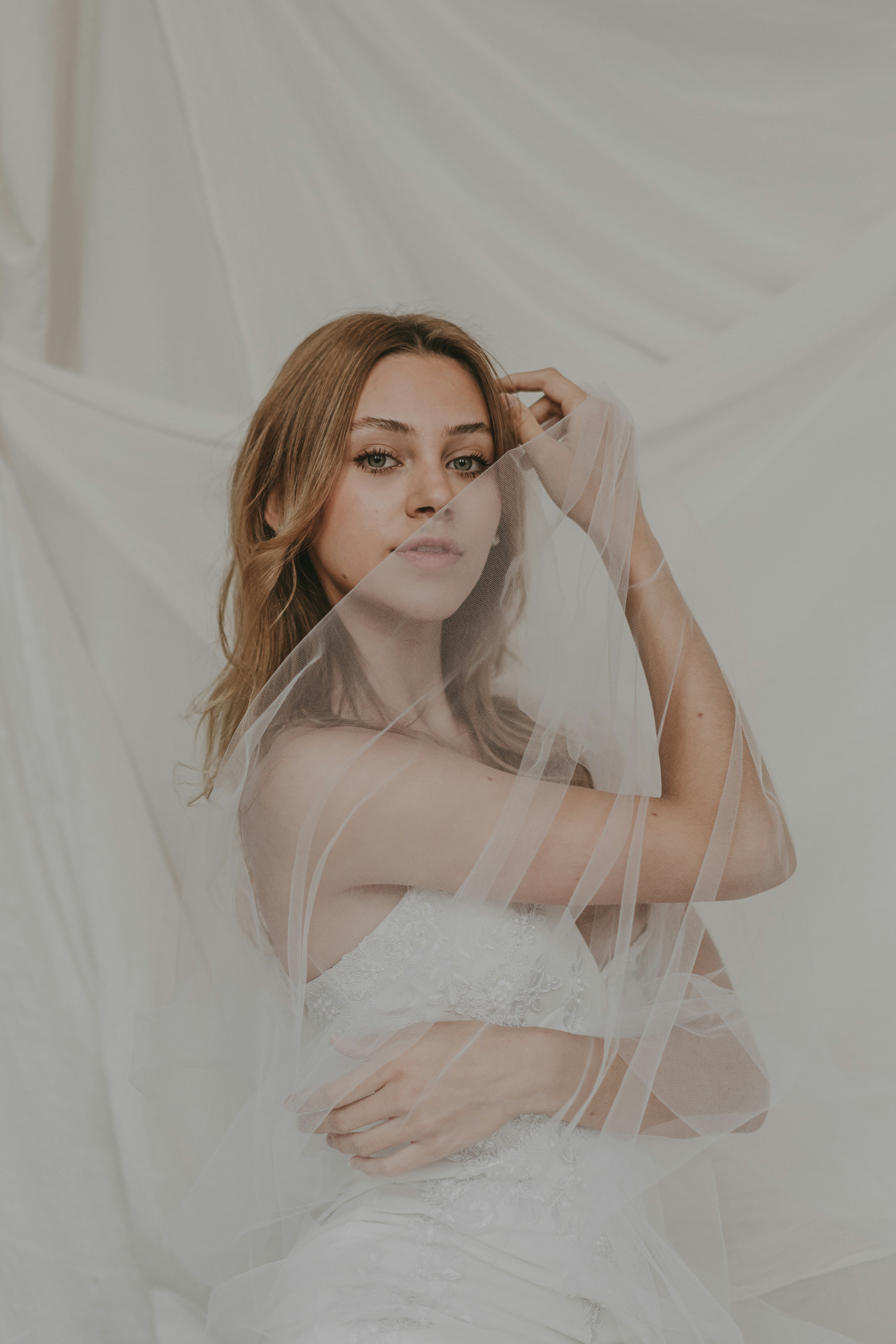 Veiled Gaze: Intimate Bridal Portrait in Soft Drapery