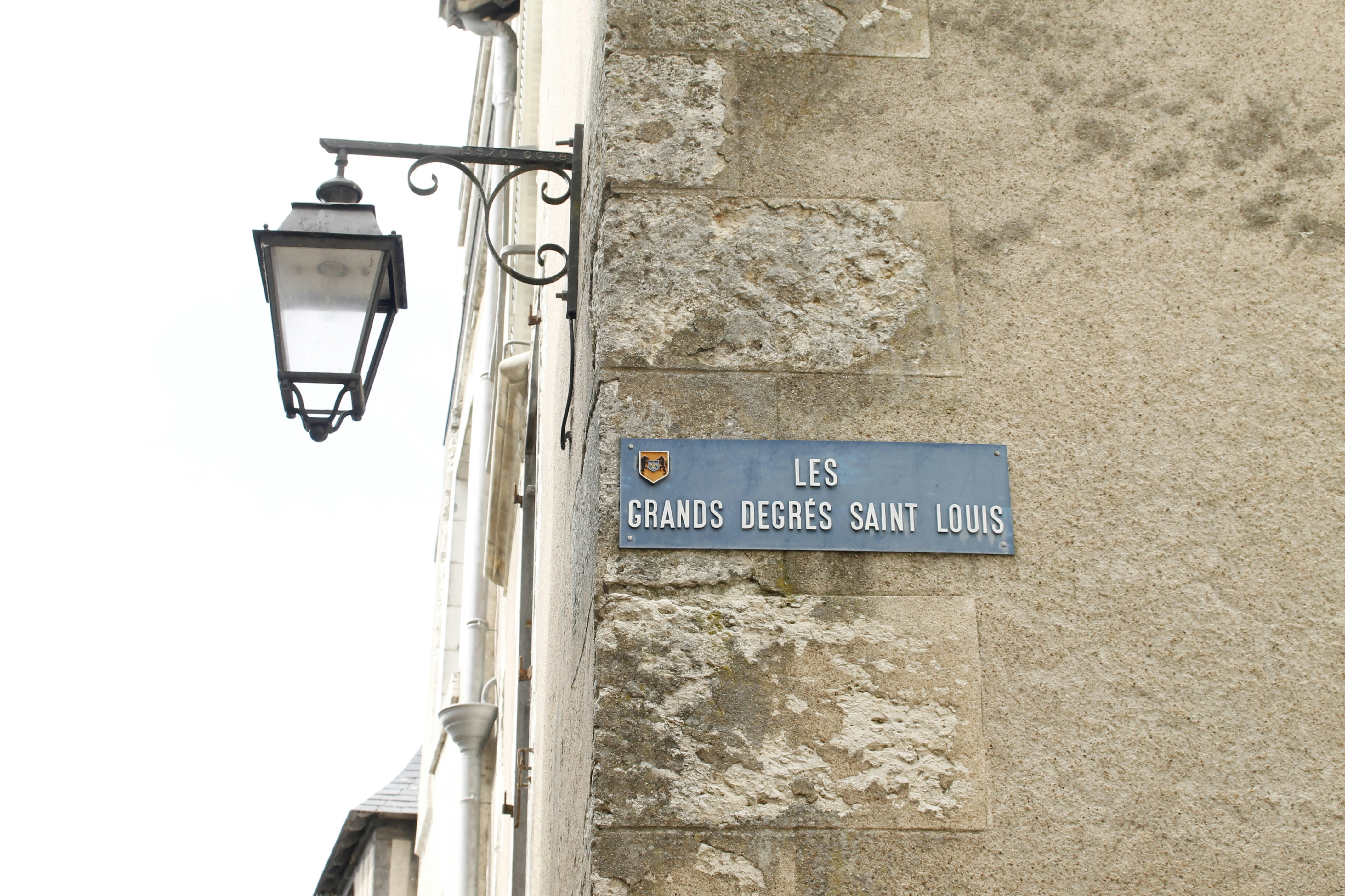Blue Plaque, Lantern, and Weathered Stone on Saint Louis Street