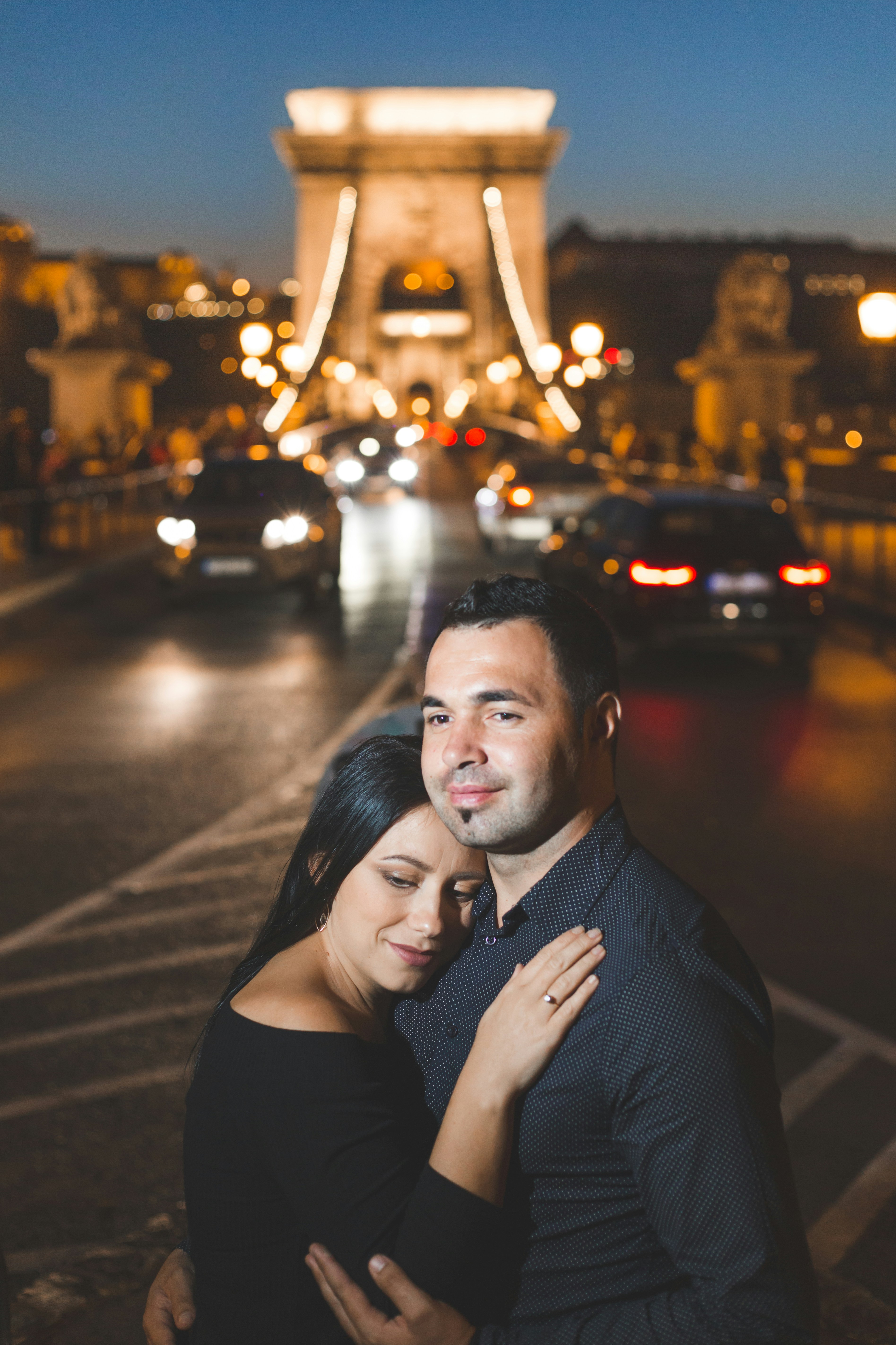 Man and women holding each other on the bridge.