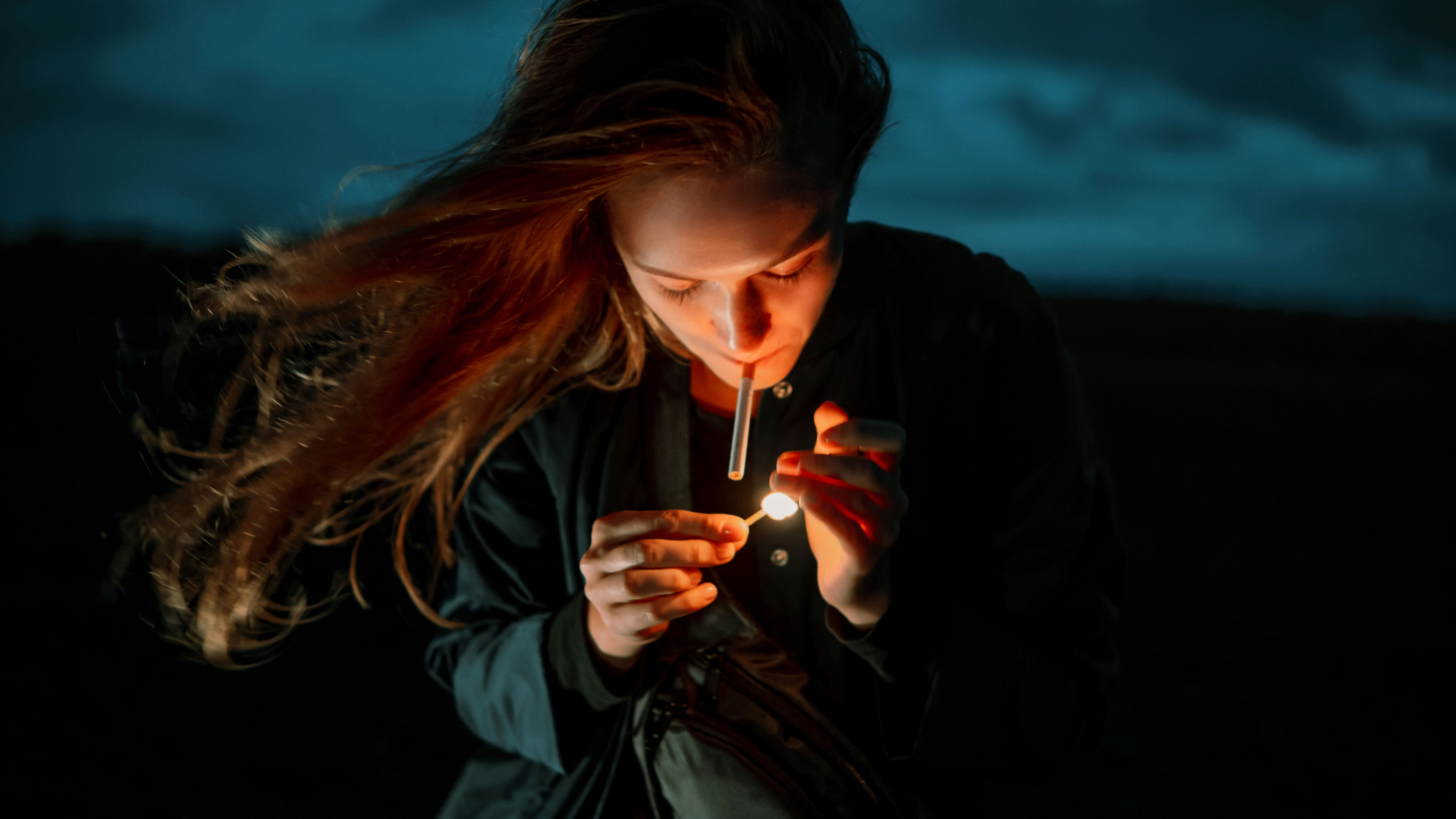 A woman holding a lighter in her hands photo – Free Human Image on Unsplash