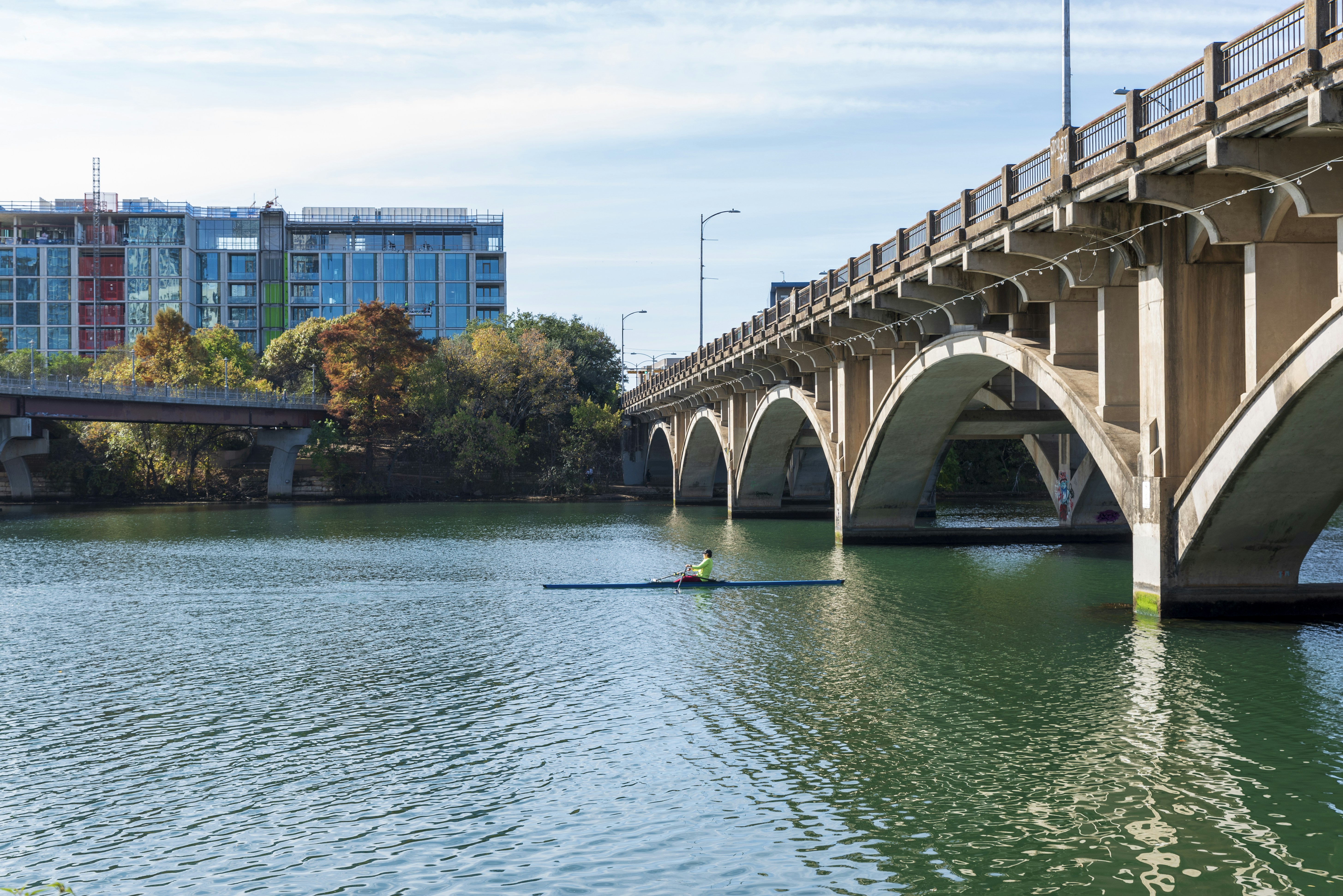 Foto Una persona remando un bote debajo de un puente – Imagen Austin ...