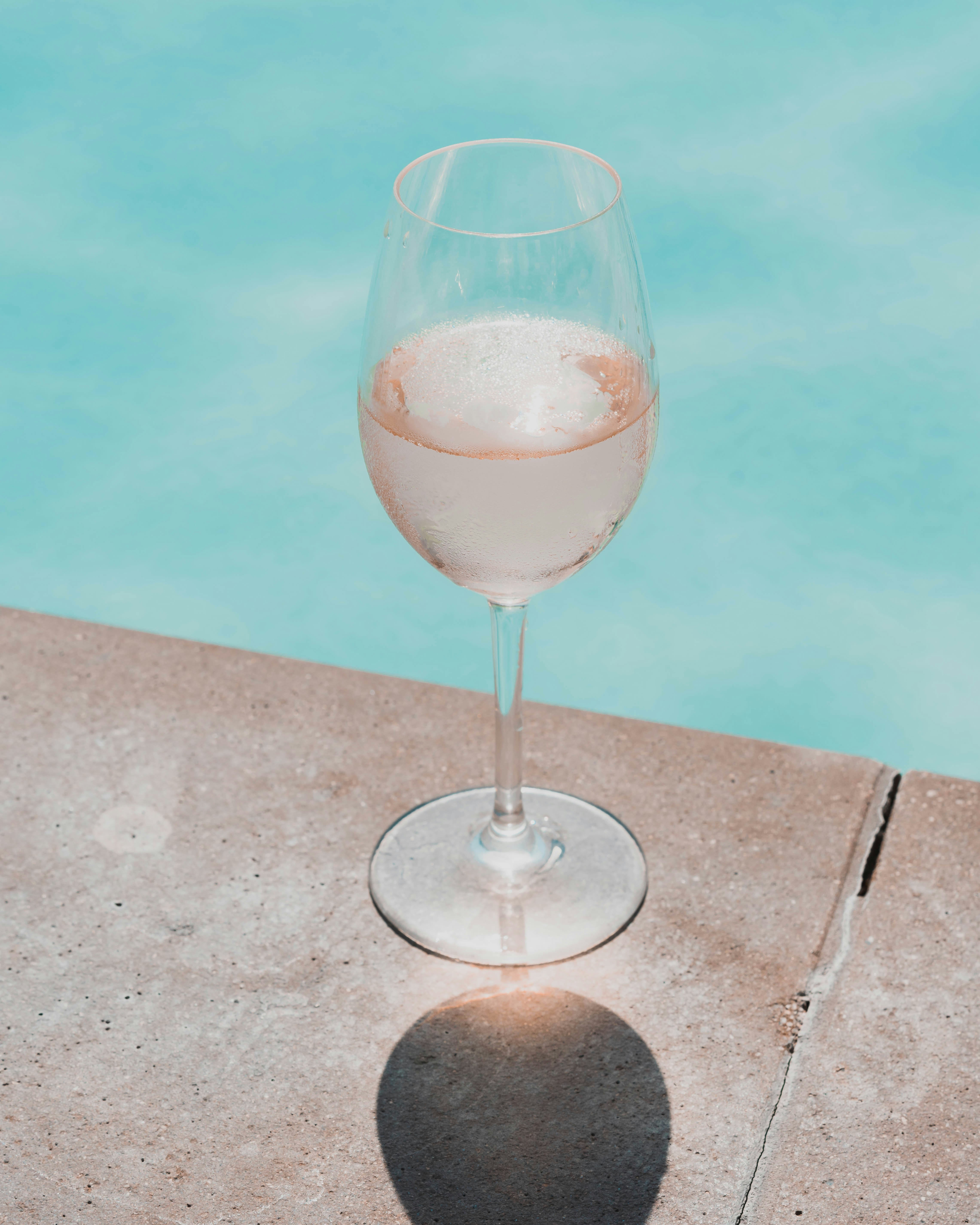 A glass of wine sitting next to a swimming pool photo – Free Usa Image ...