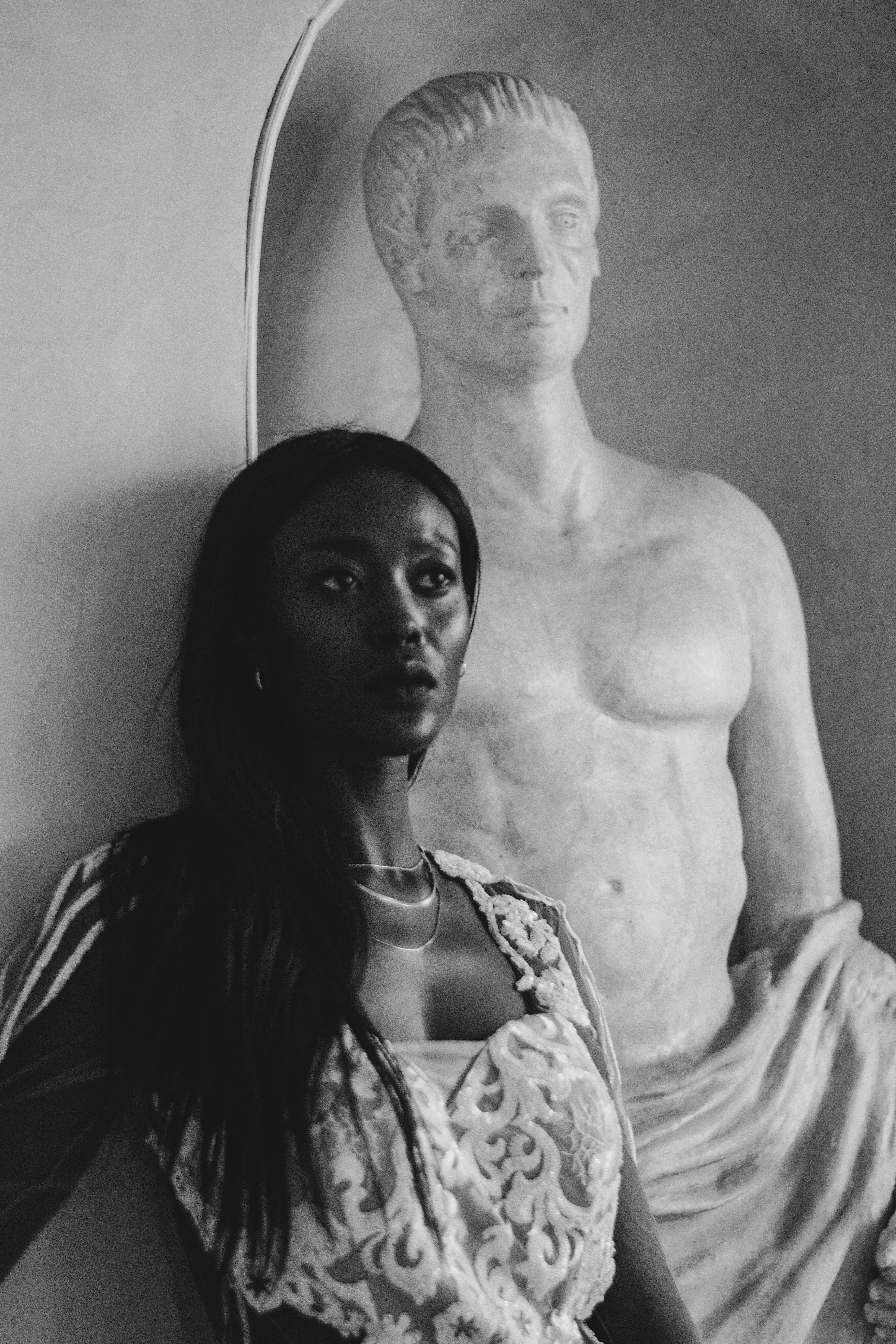 Echoes on Marble: A Woman and Classical Statue in Soft Monochrome