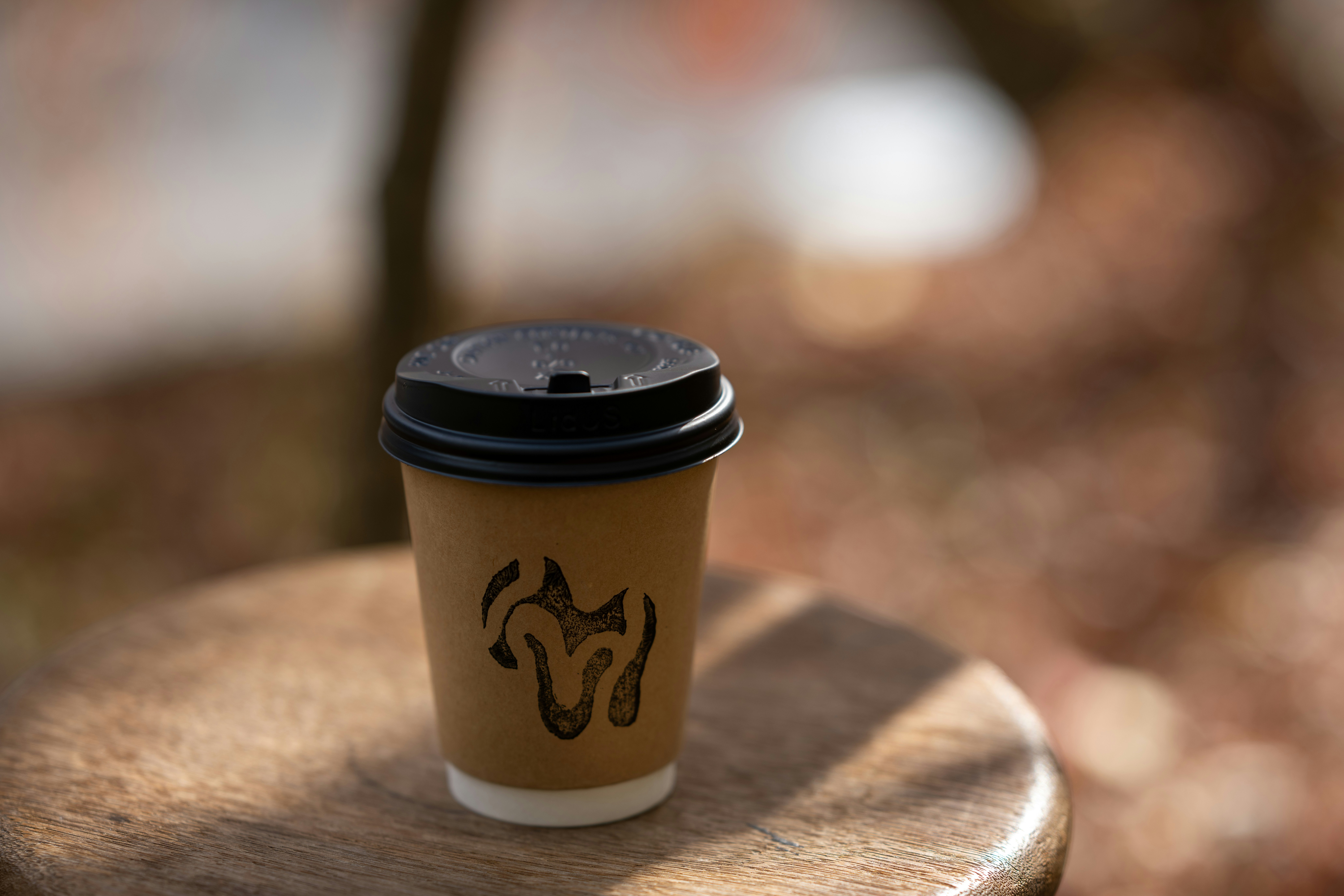 a cup of coffee sitting on top of a wooden table
