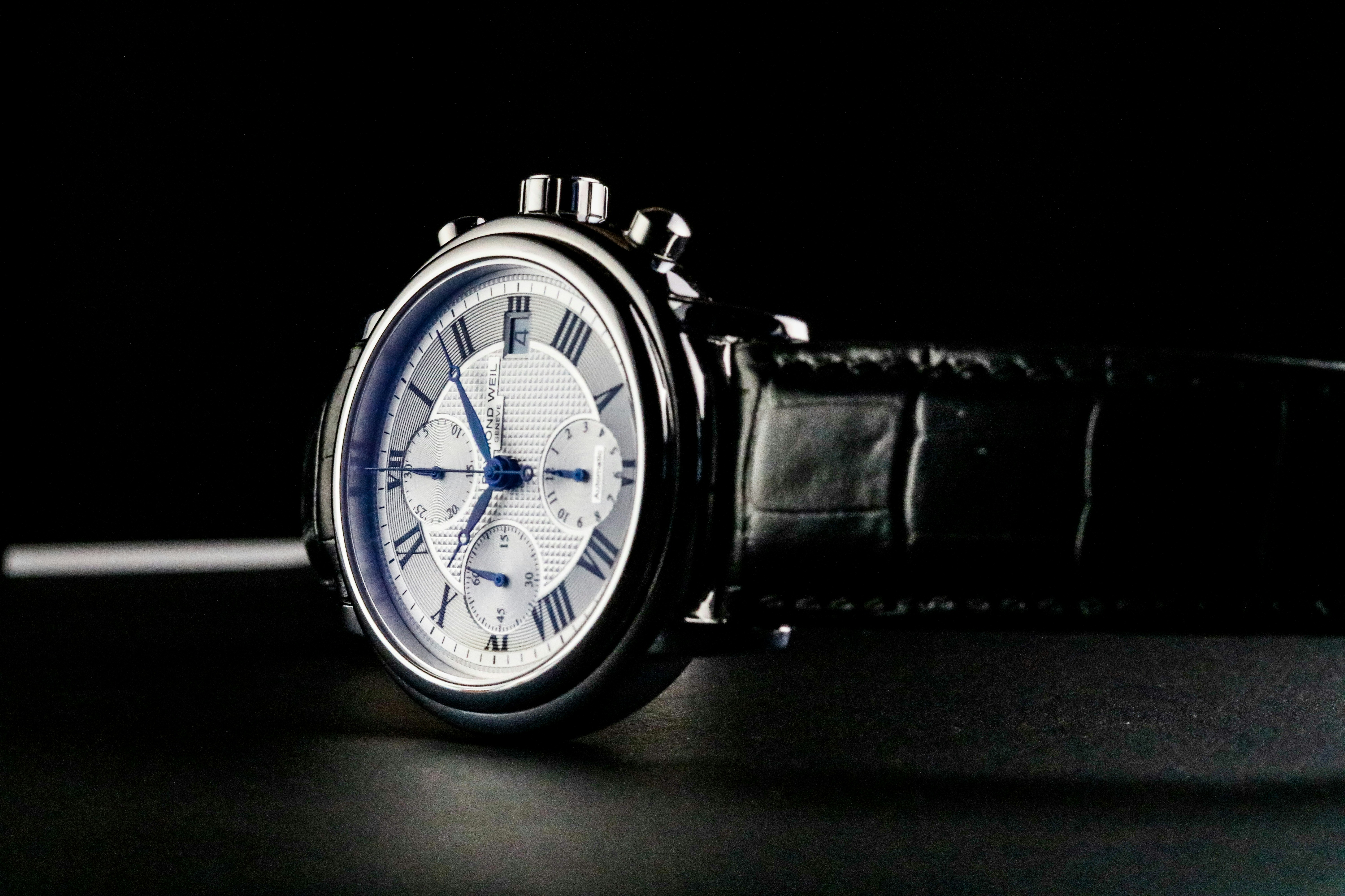 A close up of a watch on a black surface photo – Free Wristwatch Image ...