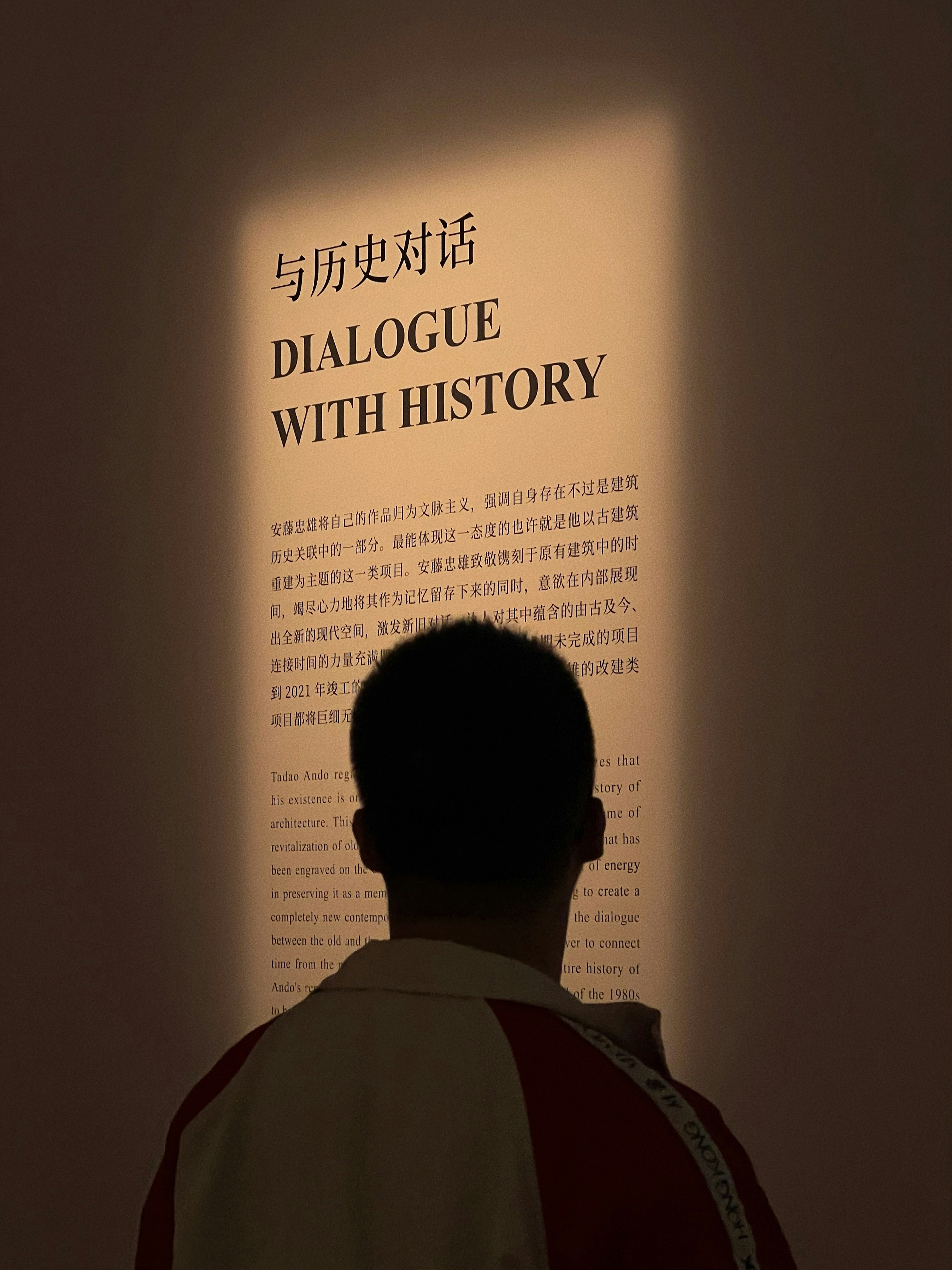 A man standing in front of a wall with a sign on it photo – Free Human ...