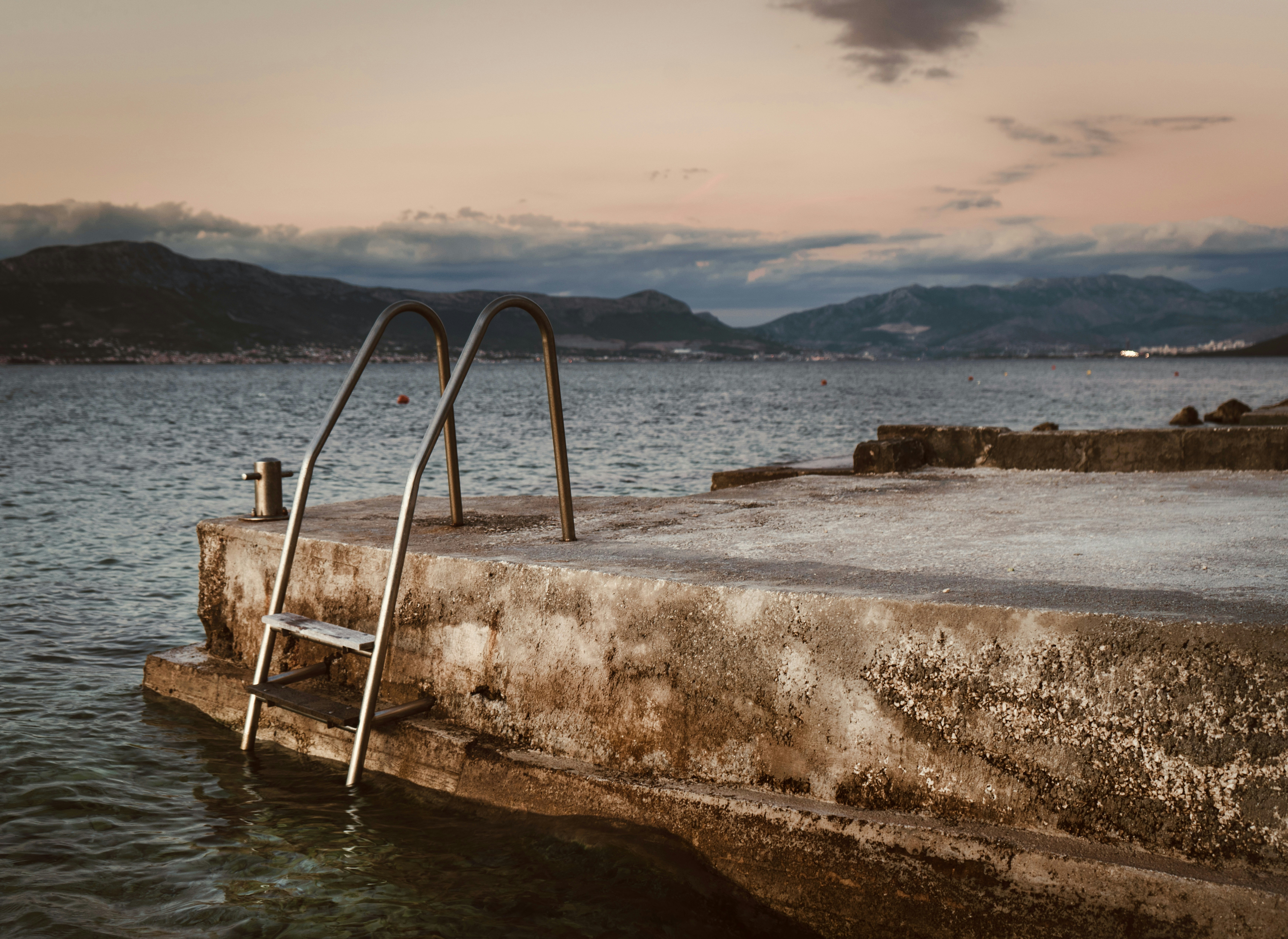 Ladder at Dusk: A Quiet Pier Reaching Toward the Sunset Sea