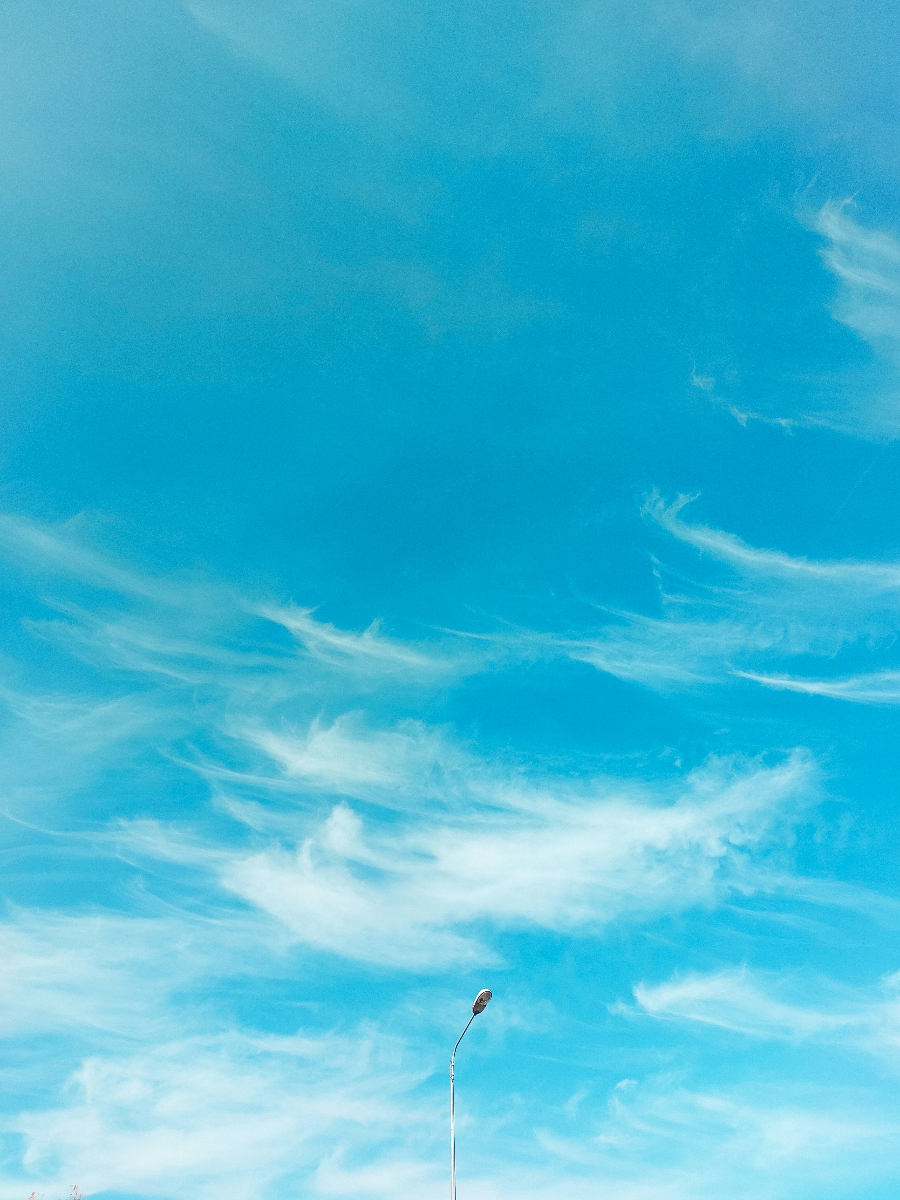 Minimalistic street photography | a person flying a kite in a blue sky