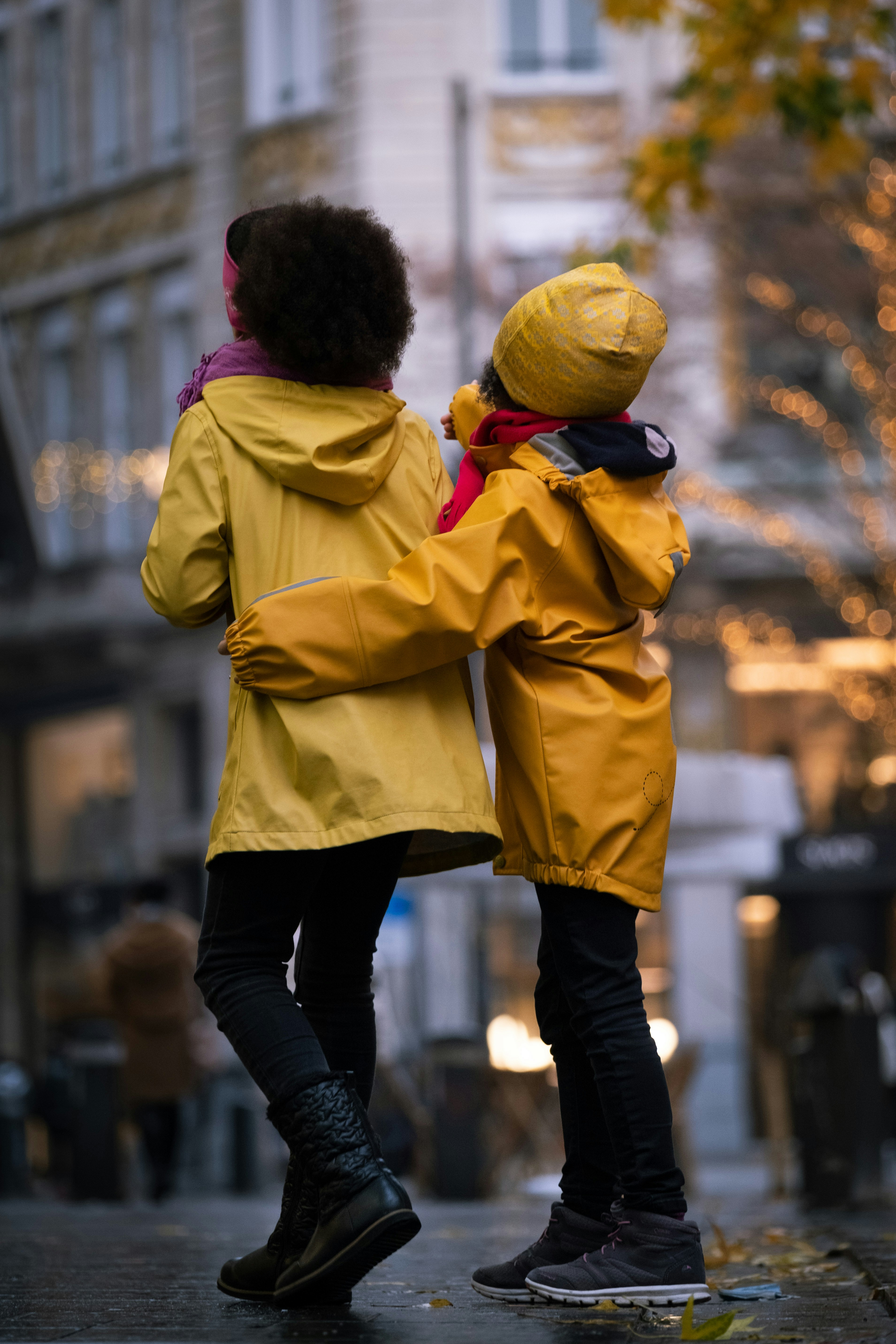 Two Yellow Raincoats Share a Quiet City Embrace at Dusk