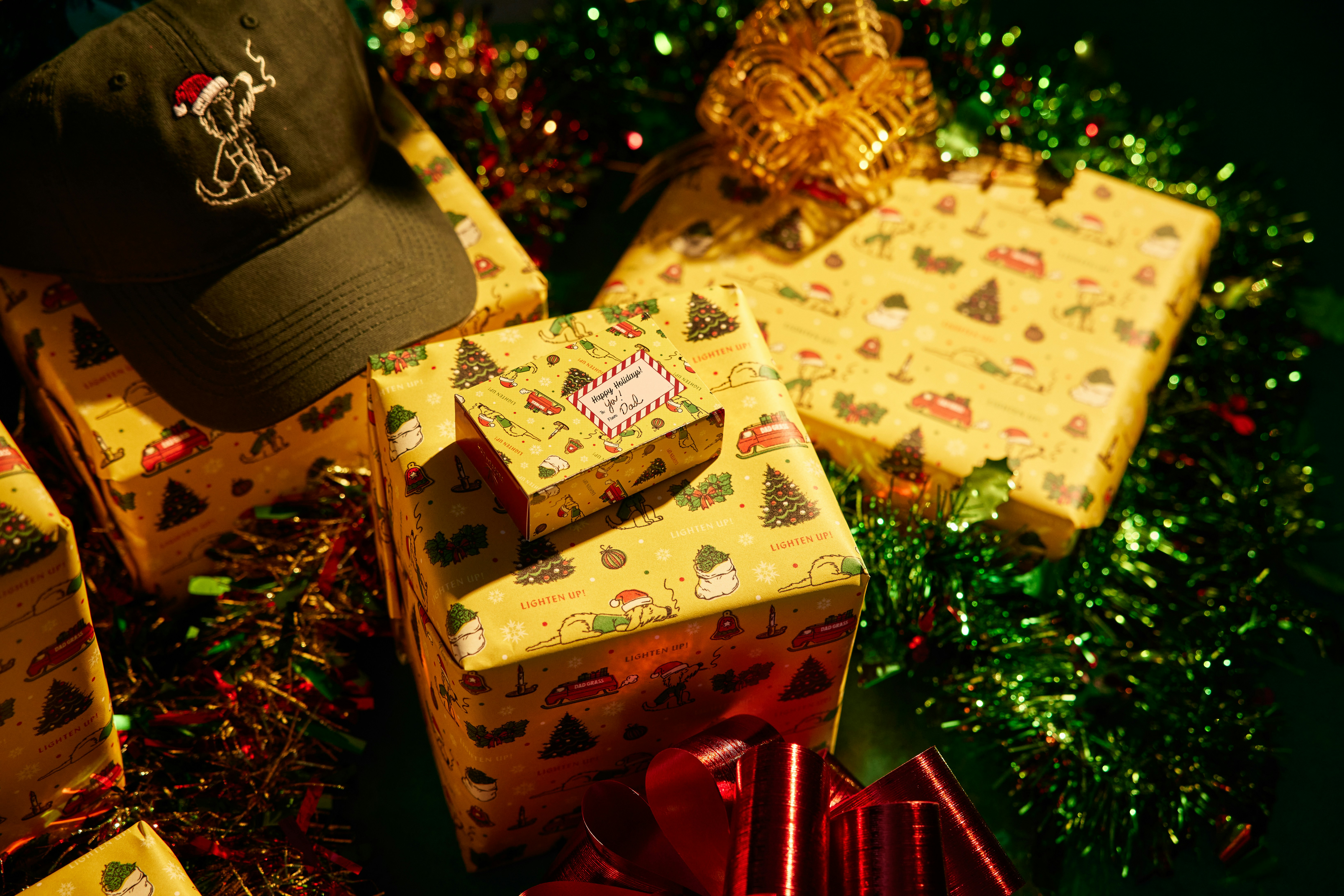 Colorful Christmas presents adorned with vibrant wrapping paper and ribbons, accompanied by a playful hat, create a festive atmosphere of holiday excitement.