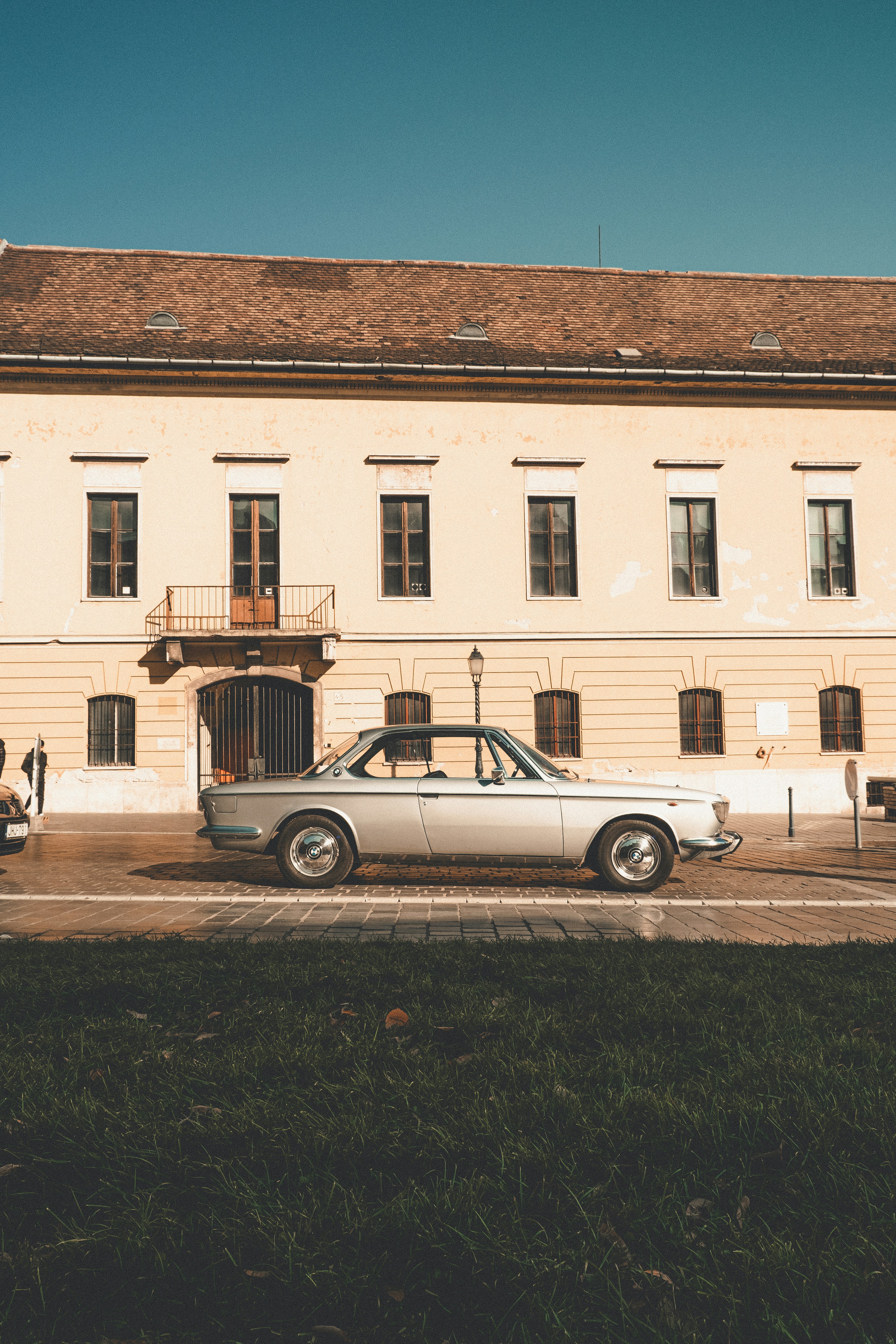Retro Royal Rumble: Classic Car Against a Sunlit Facade
