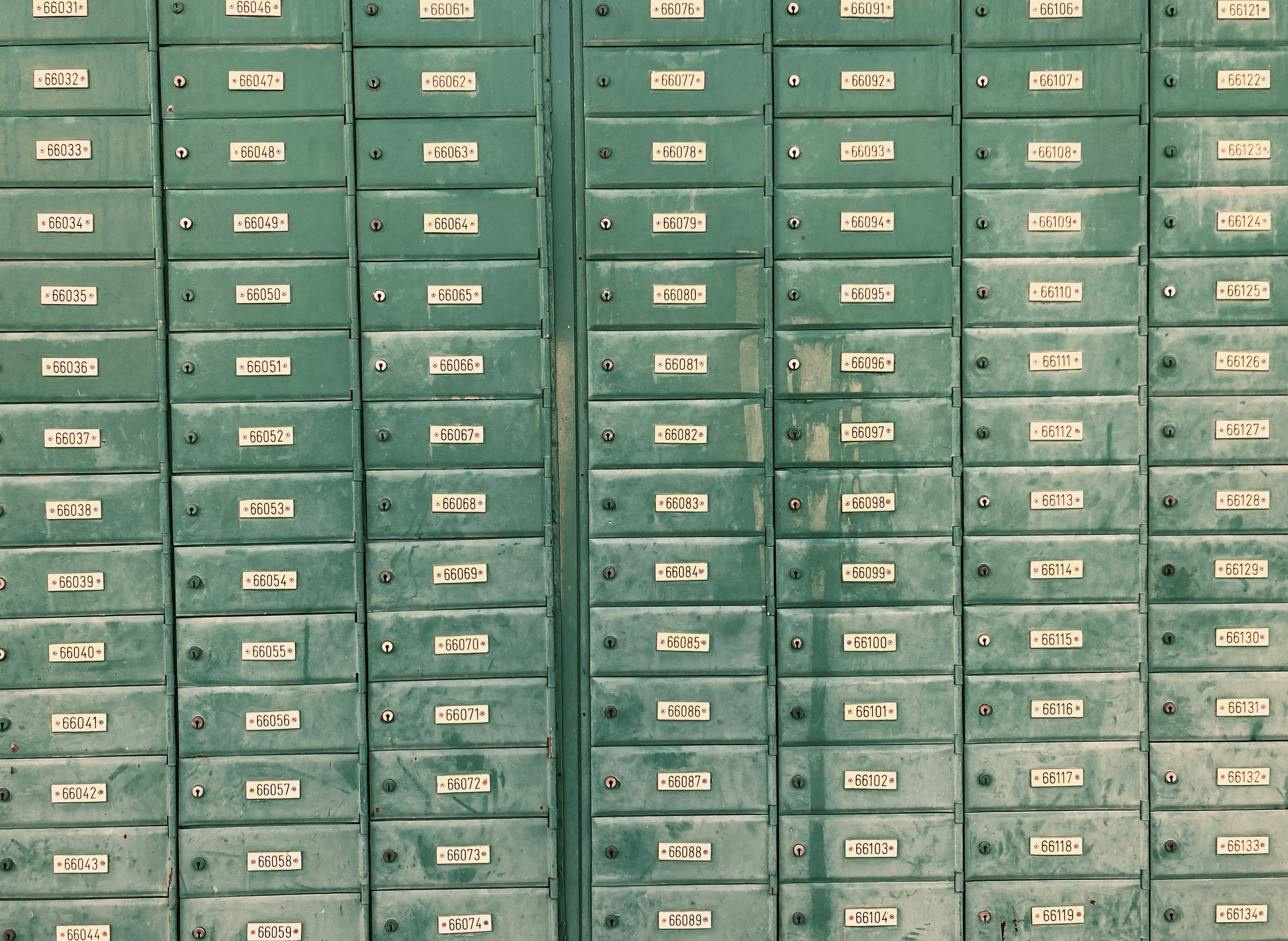 A row of green mail boxes with white labels on them photo – Free ...