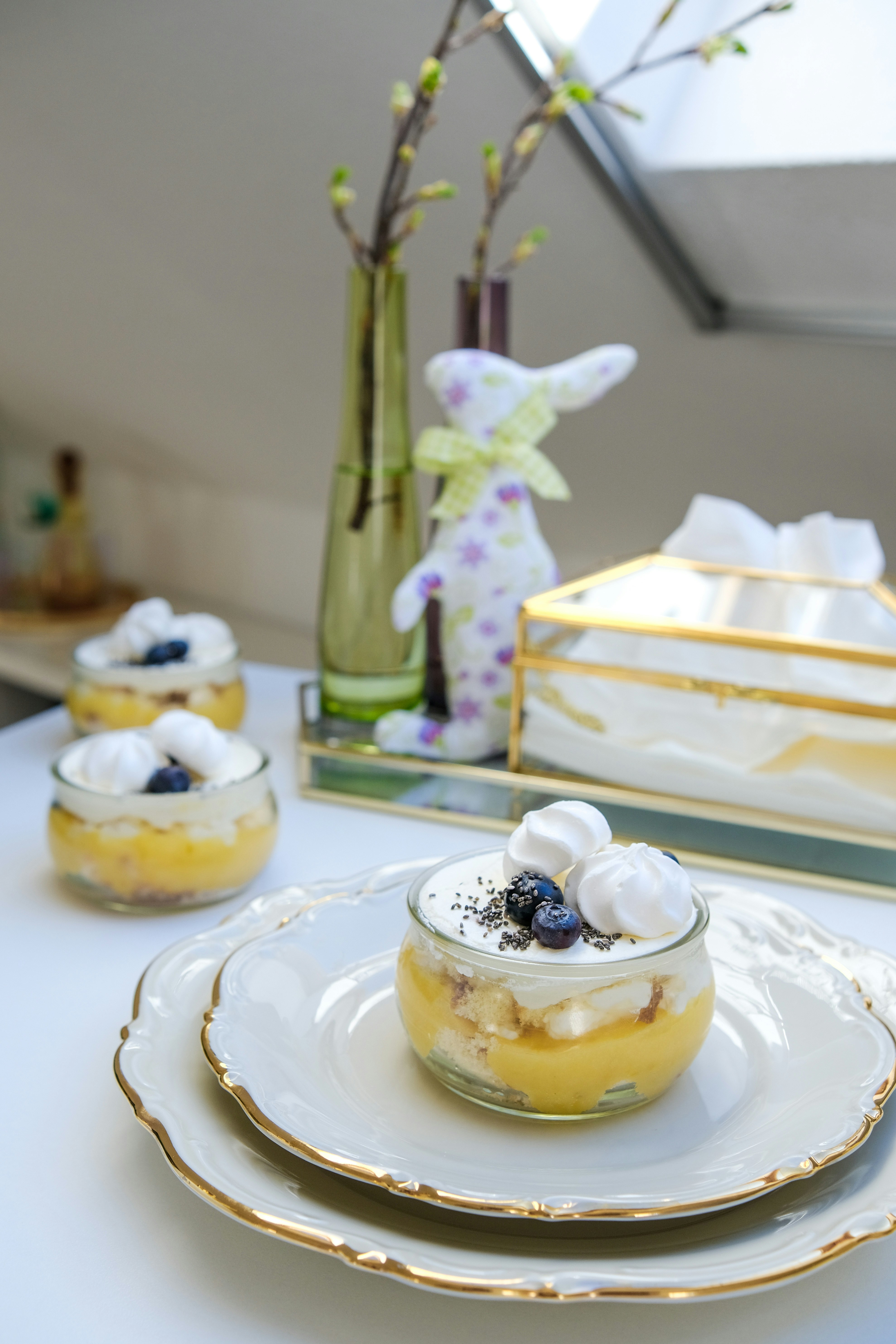 A table topped with desserts and a vase filled with flowers photo ...