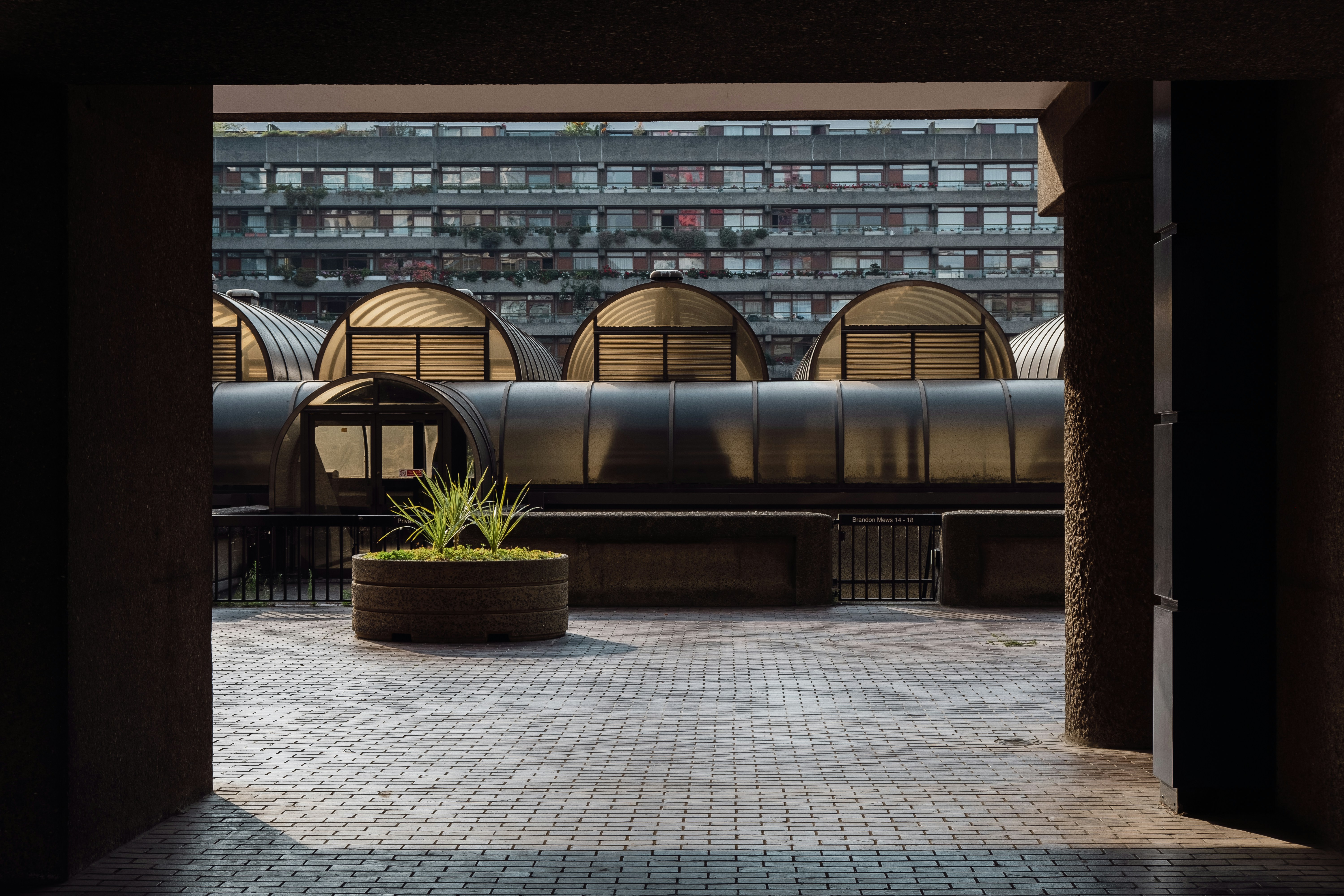 A courtyard with benches and plants in it photo – Free Barbican Image ...