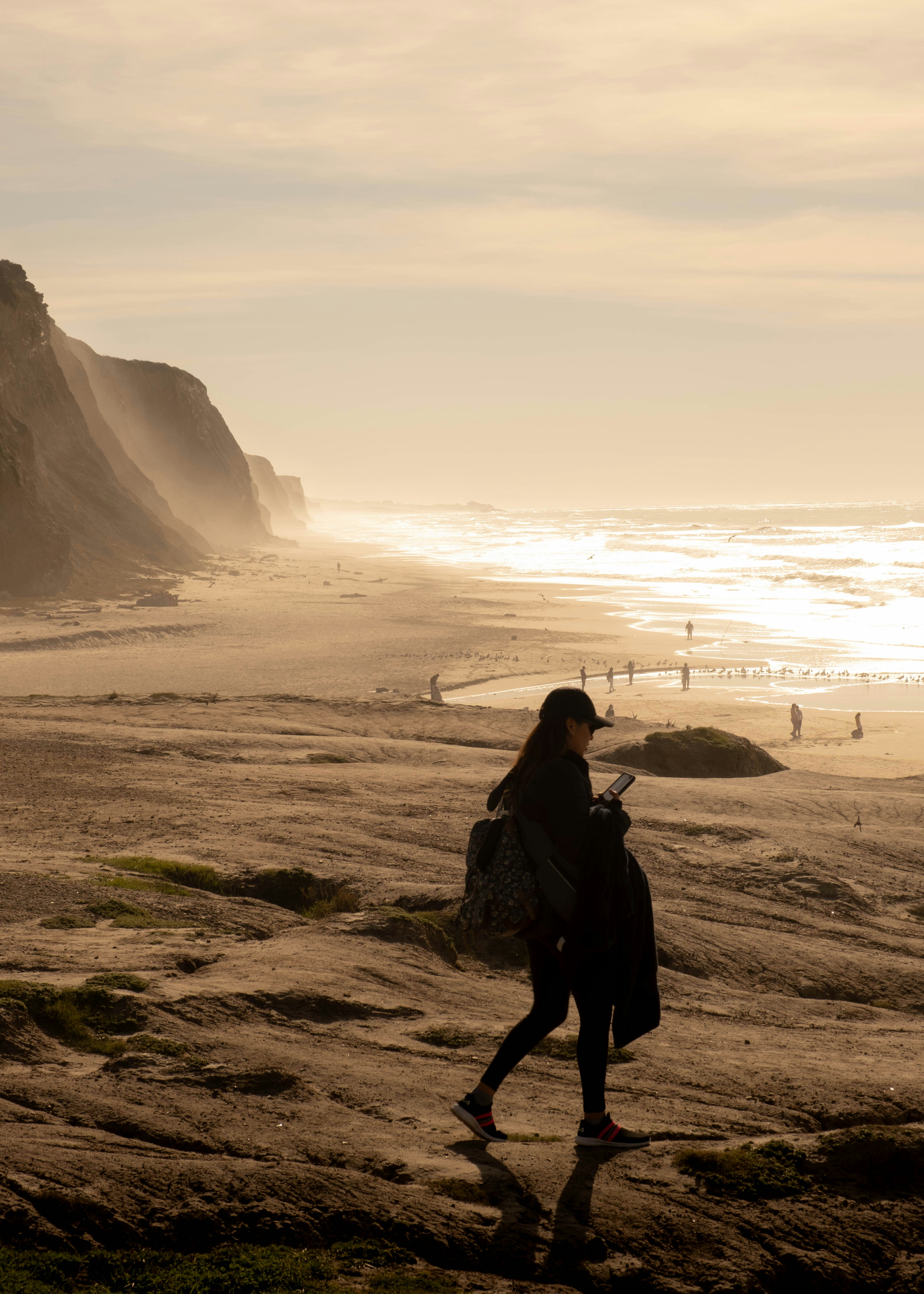 Amber Hour Wanderer: A lone figure along sunlit cliffs