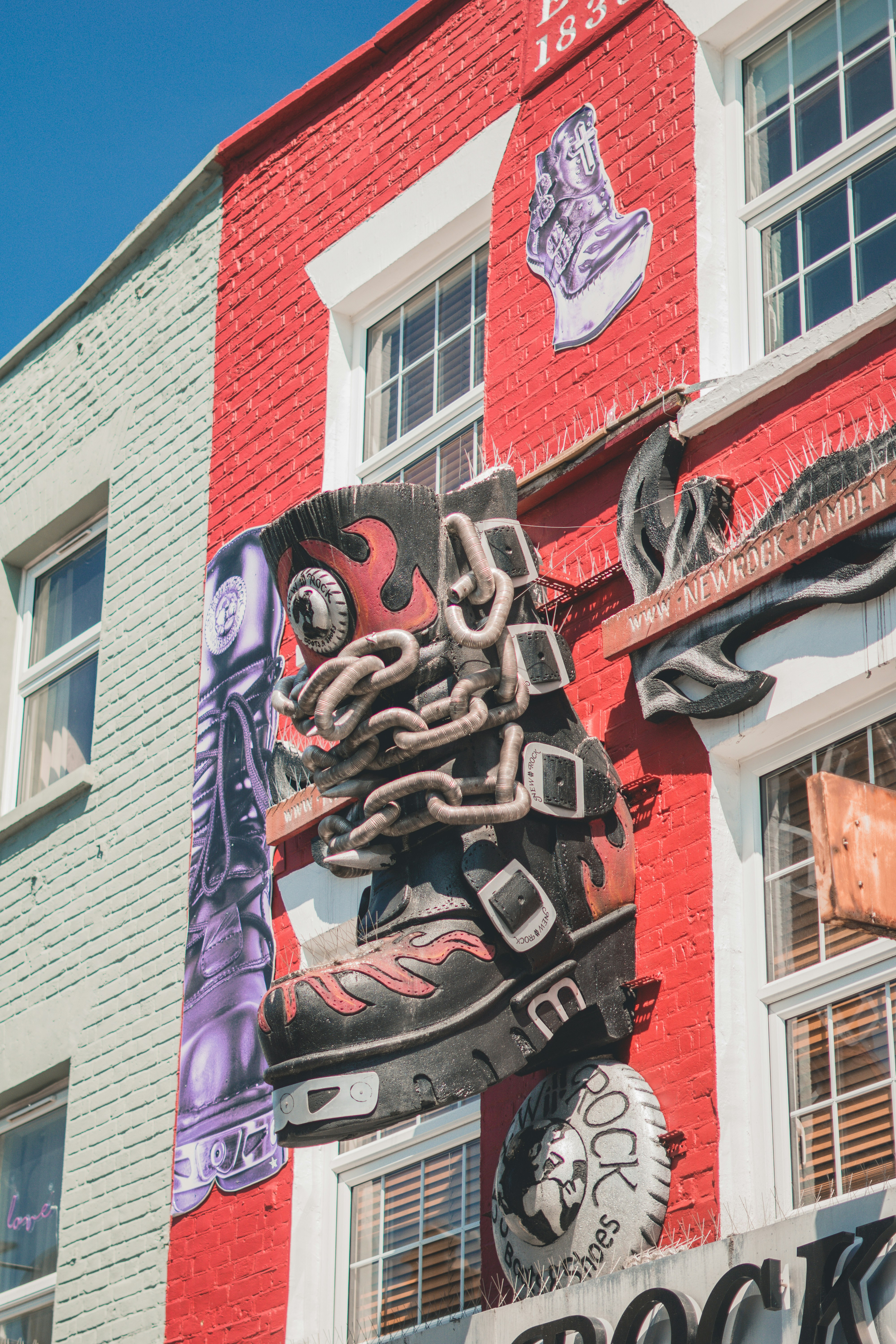 Street Art Boot: A Sneaker Emerges from the Red Brick Wall