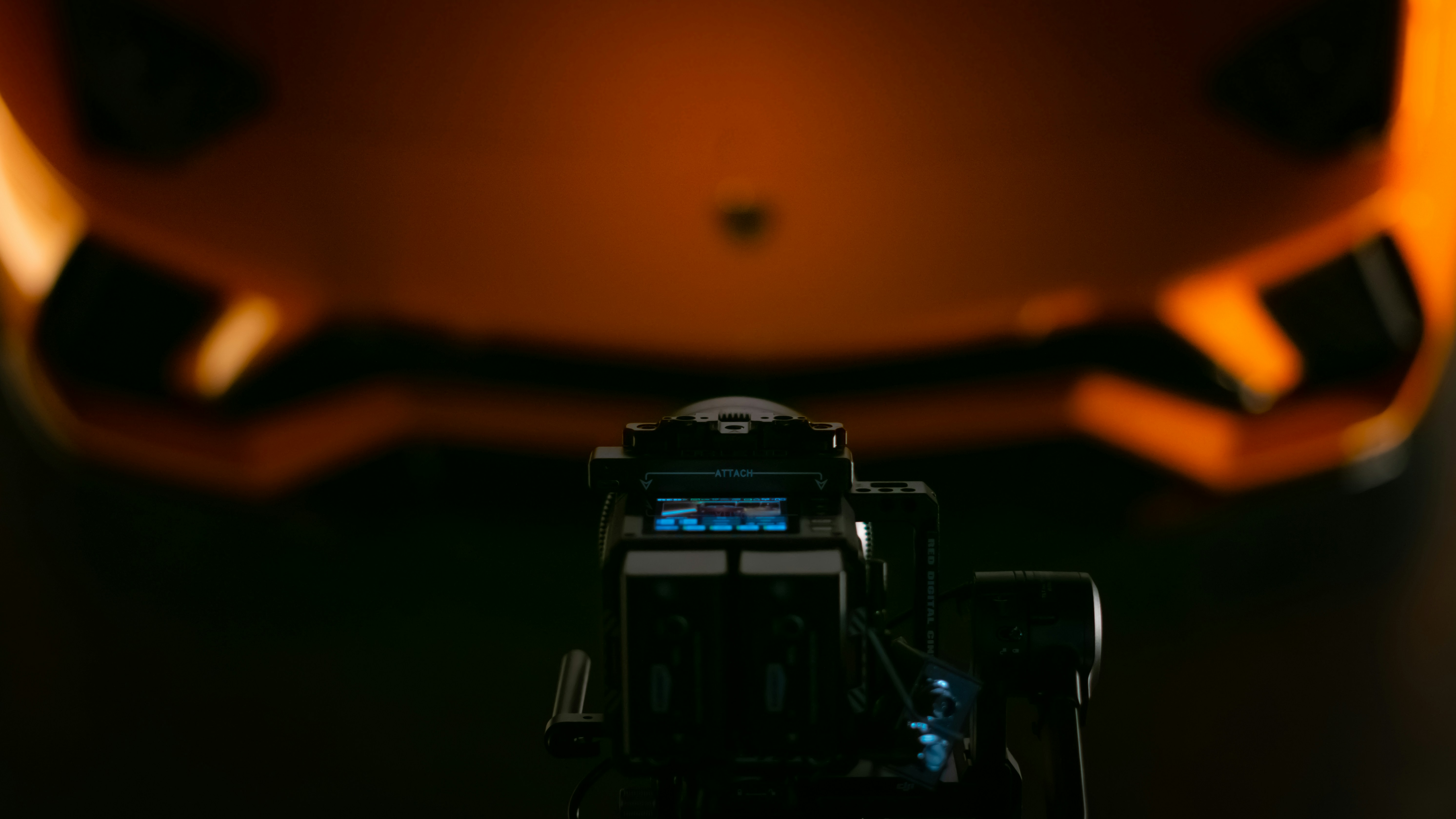 a close up of a camera with a helmet in the background