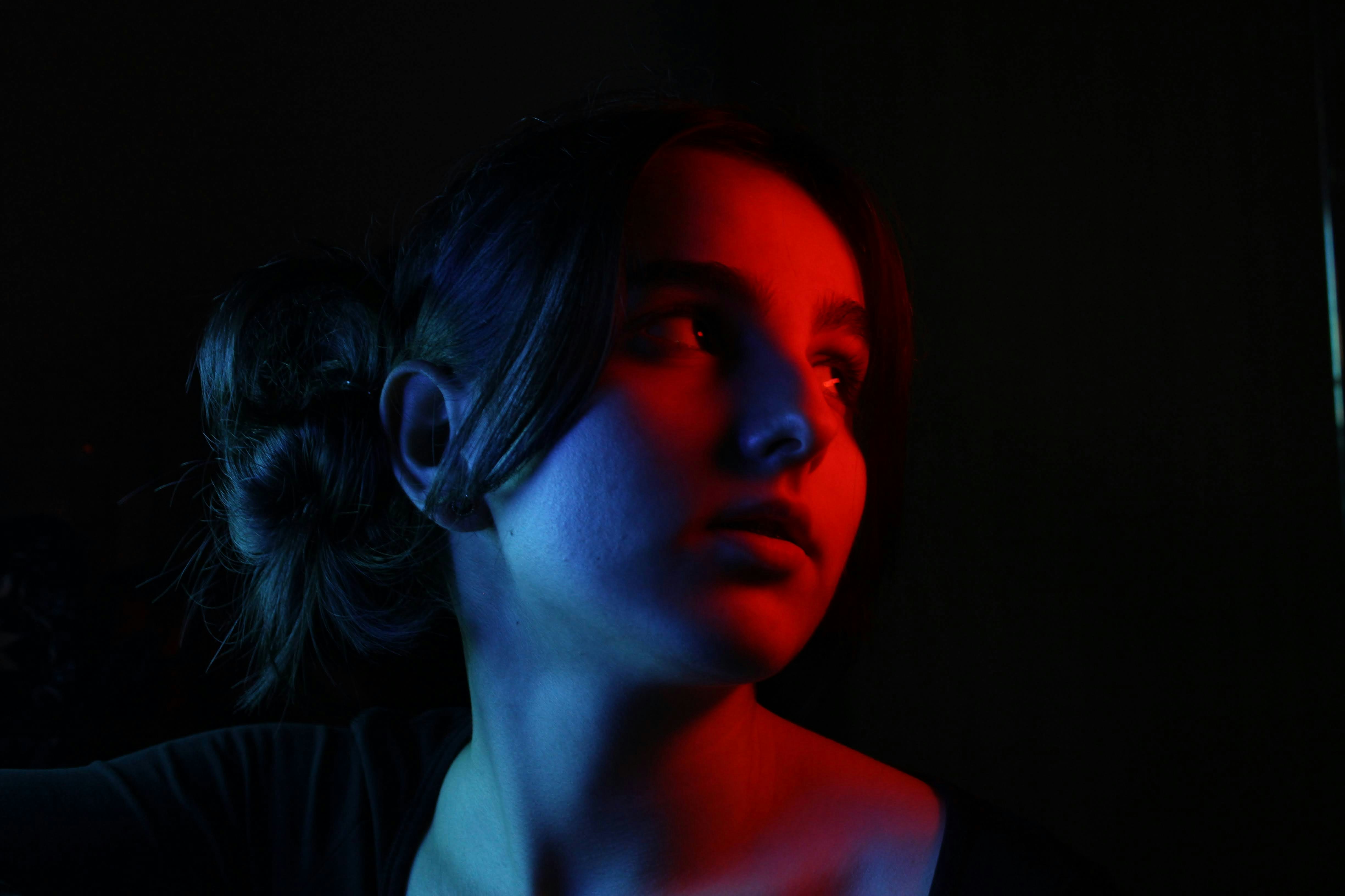 A woman in a dark room with a red light photo – Free Face Image on Unsplash