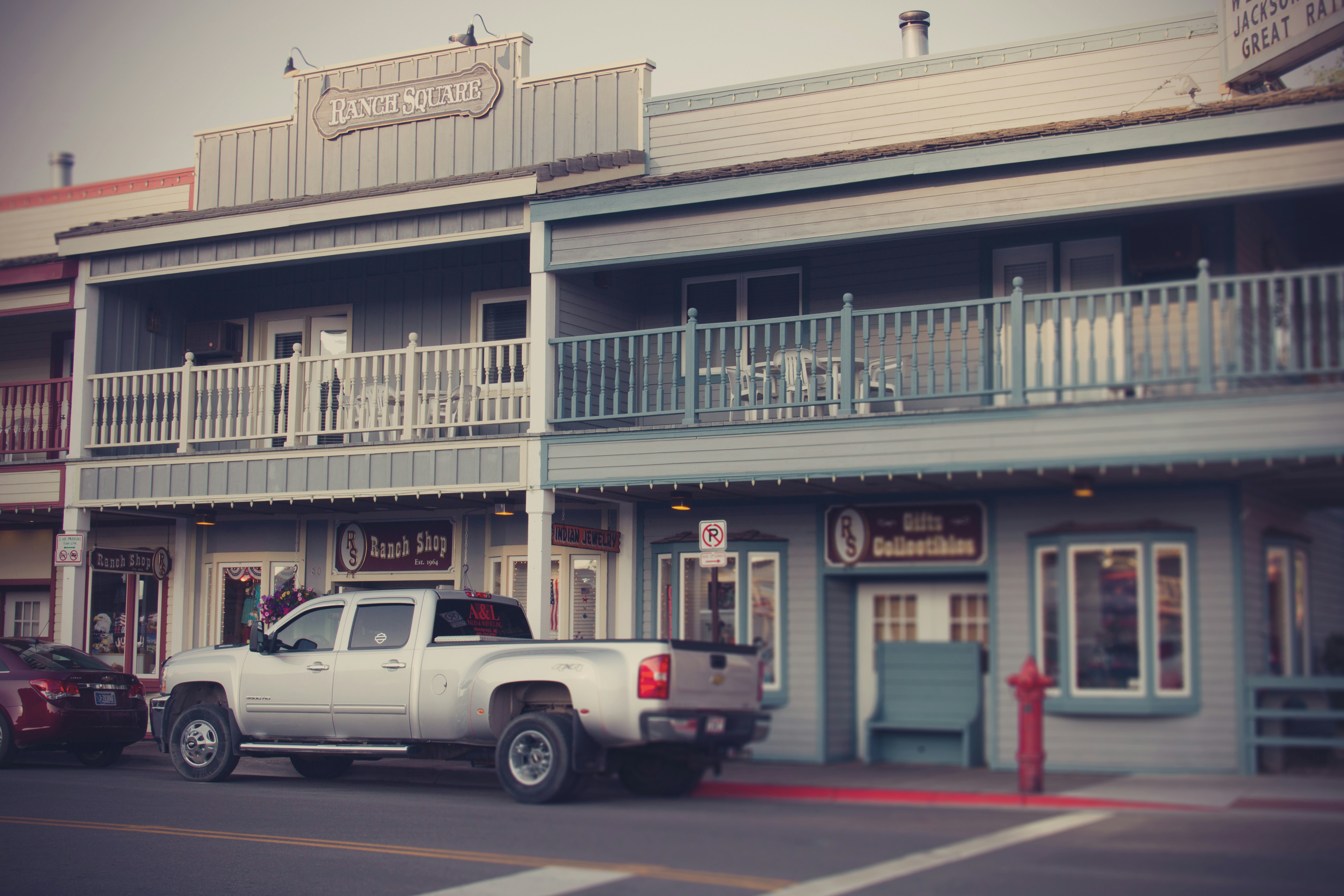 Ranch Row Quiet: White Pickup Prepares Under Weathered Verandas
