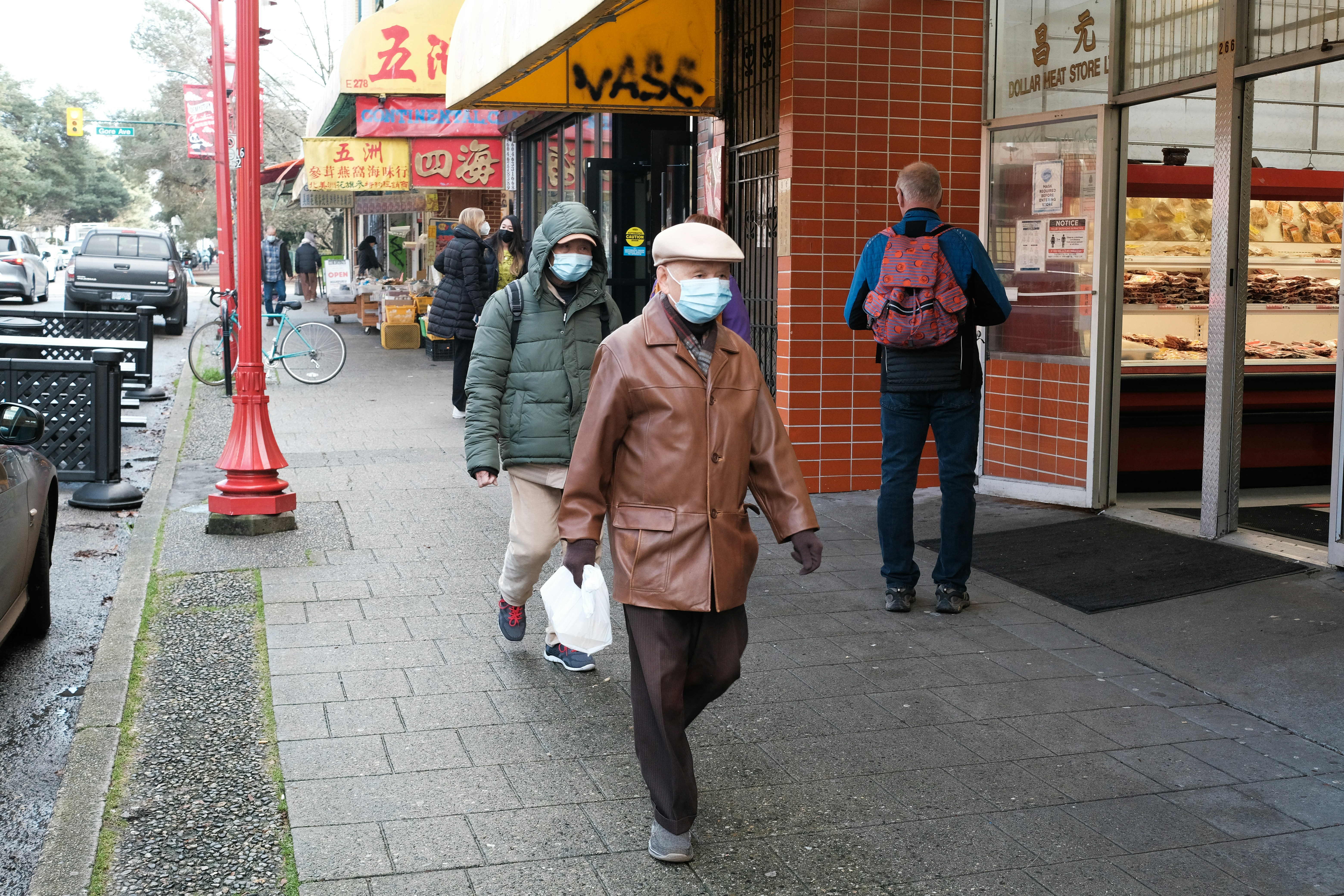 a group of people walking down a sidewalk