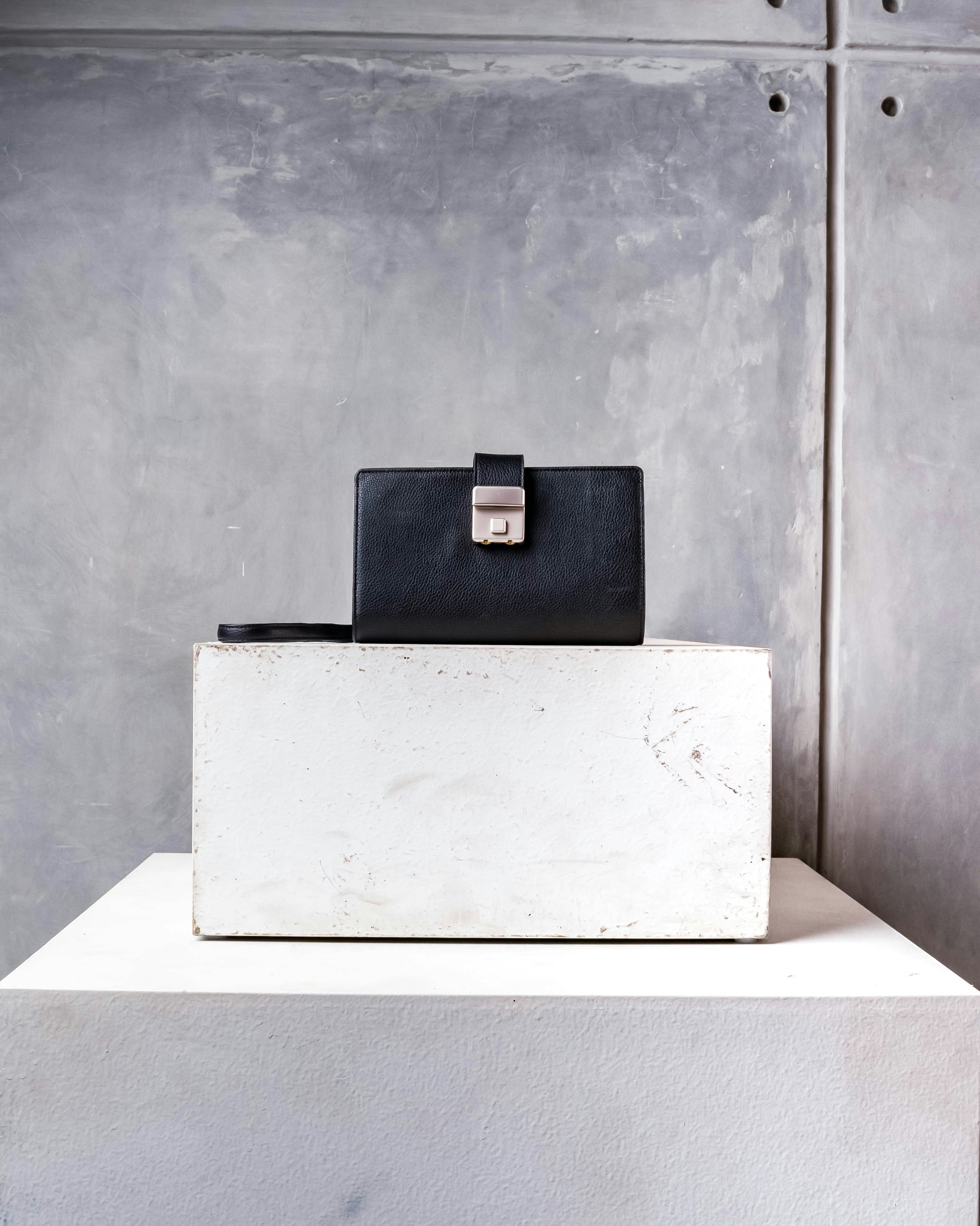 a black purse sitting on top of a white box