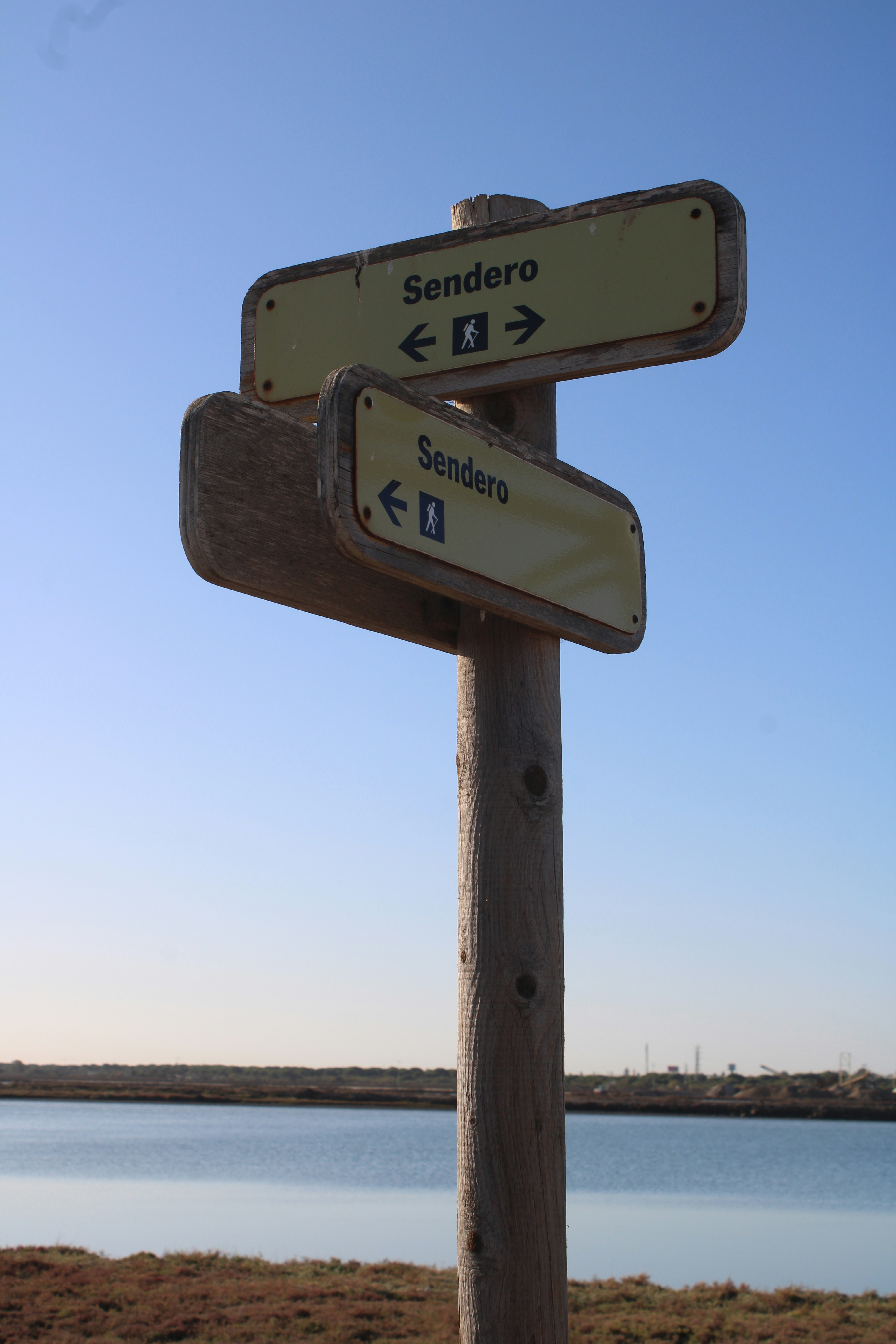 a wooden pole with two street signs on top of it