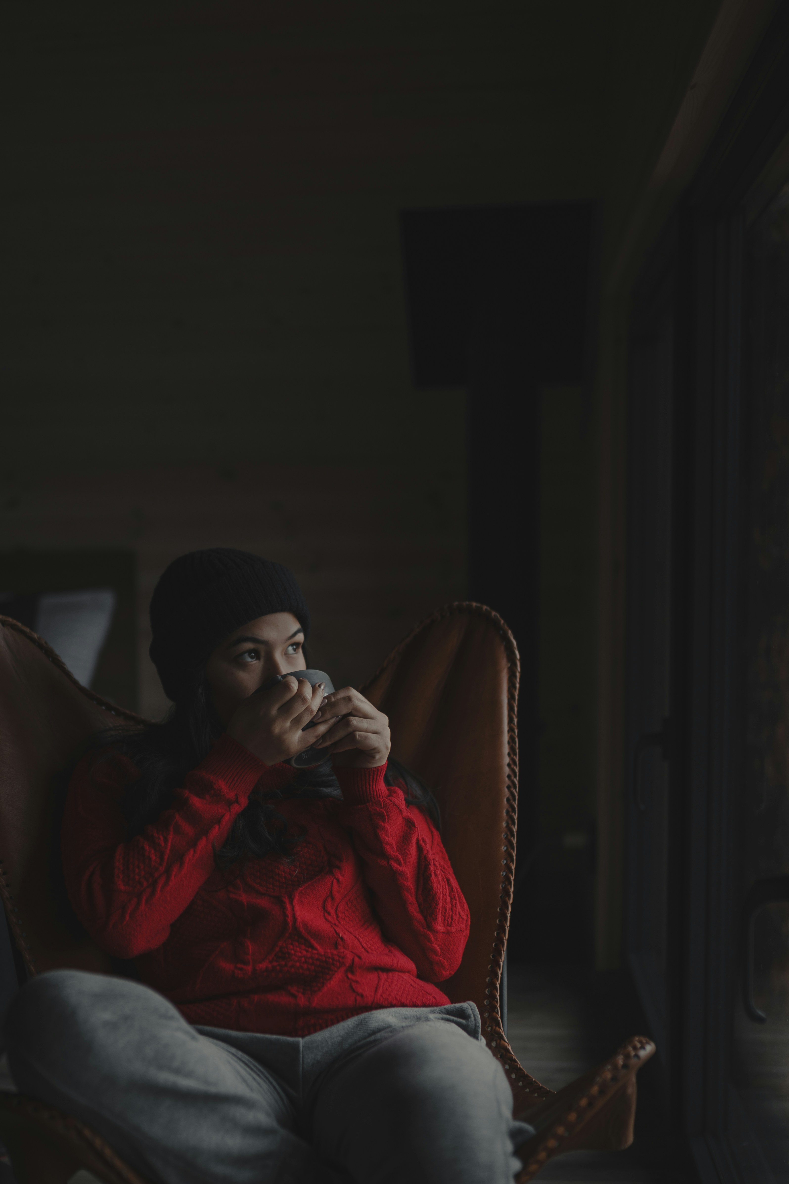 a person sitting in a chair with a cup in their hand