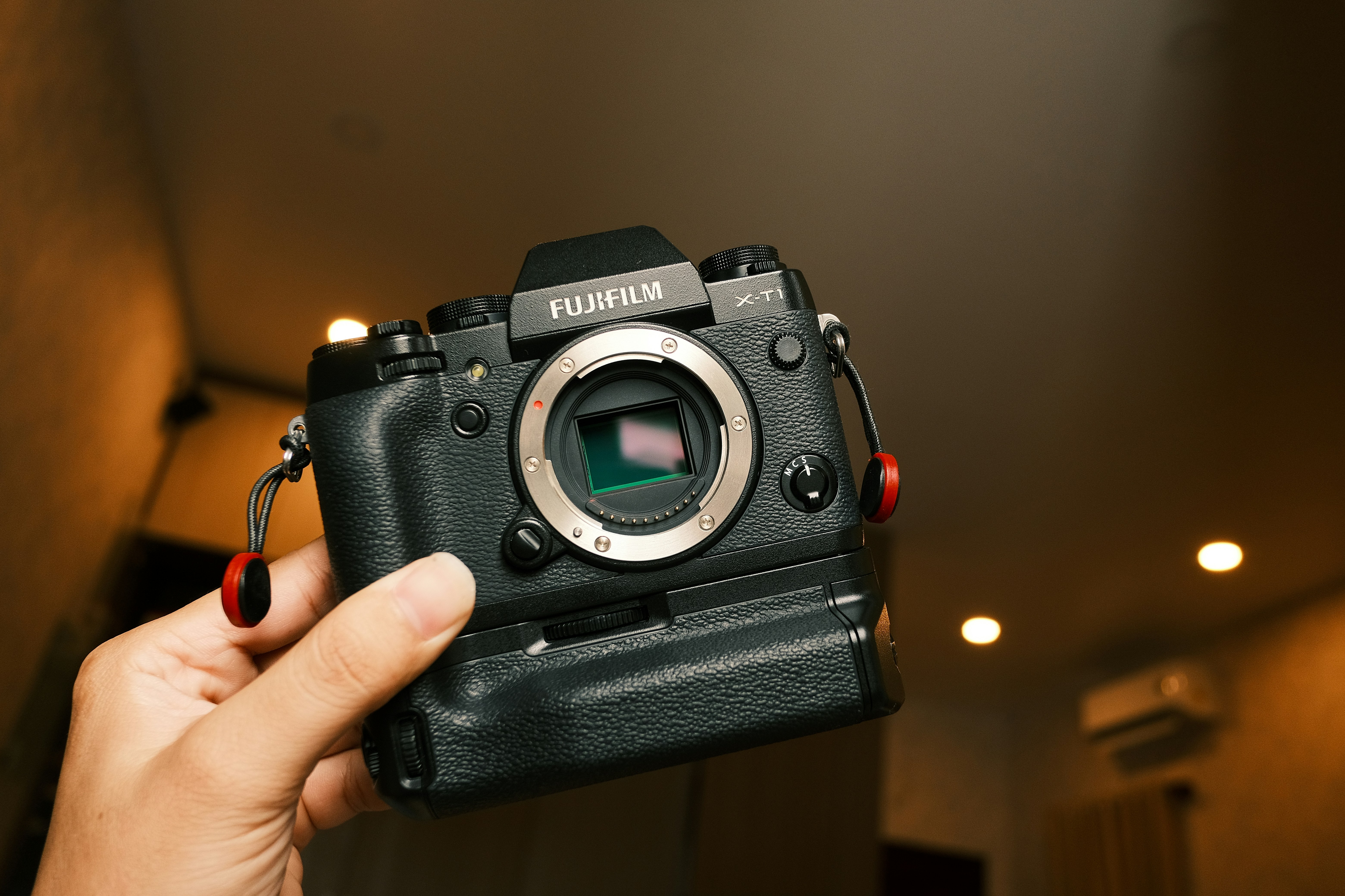 Lensless Readiness: The X-Pro3 in Hand Under Warm Indoor Lights