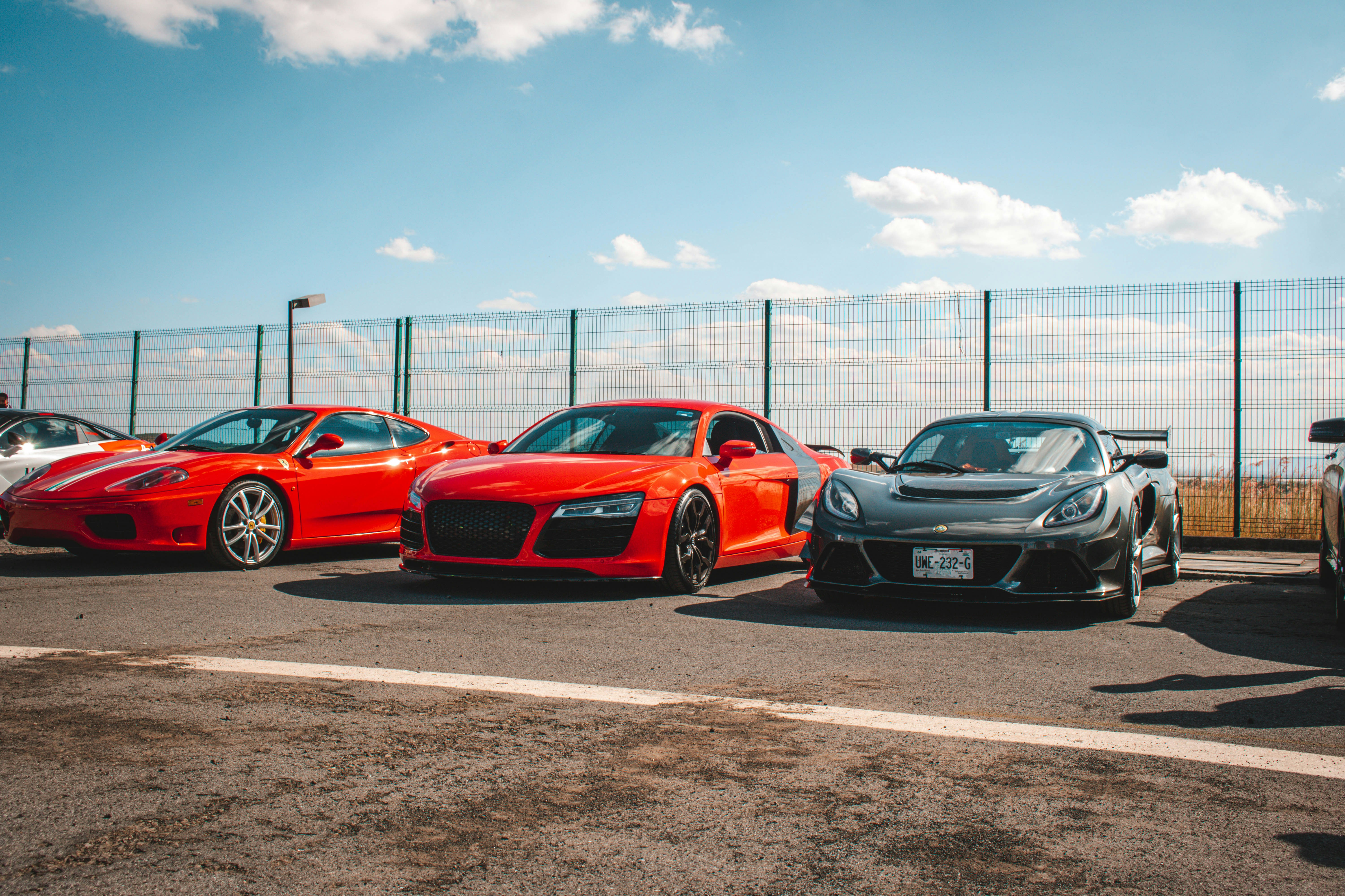 A group of three sports cars parked next to each other photo – Free ...